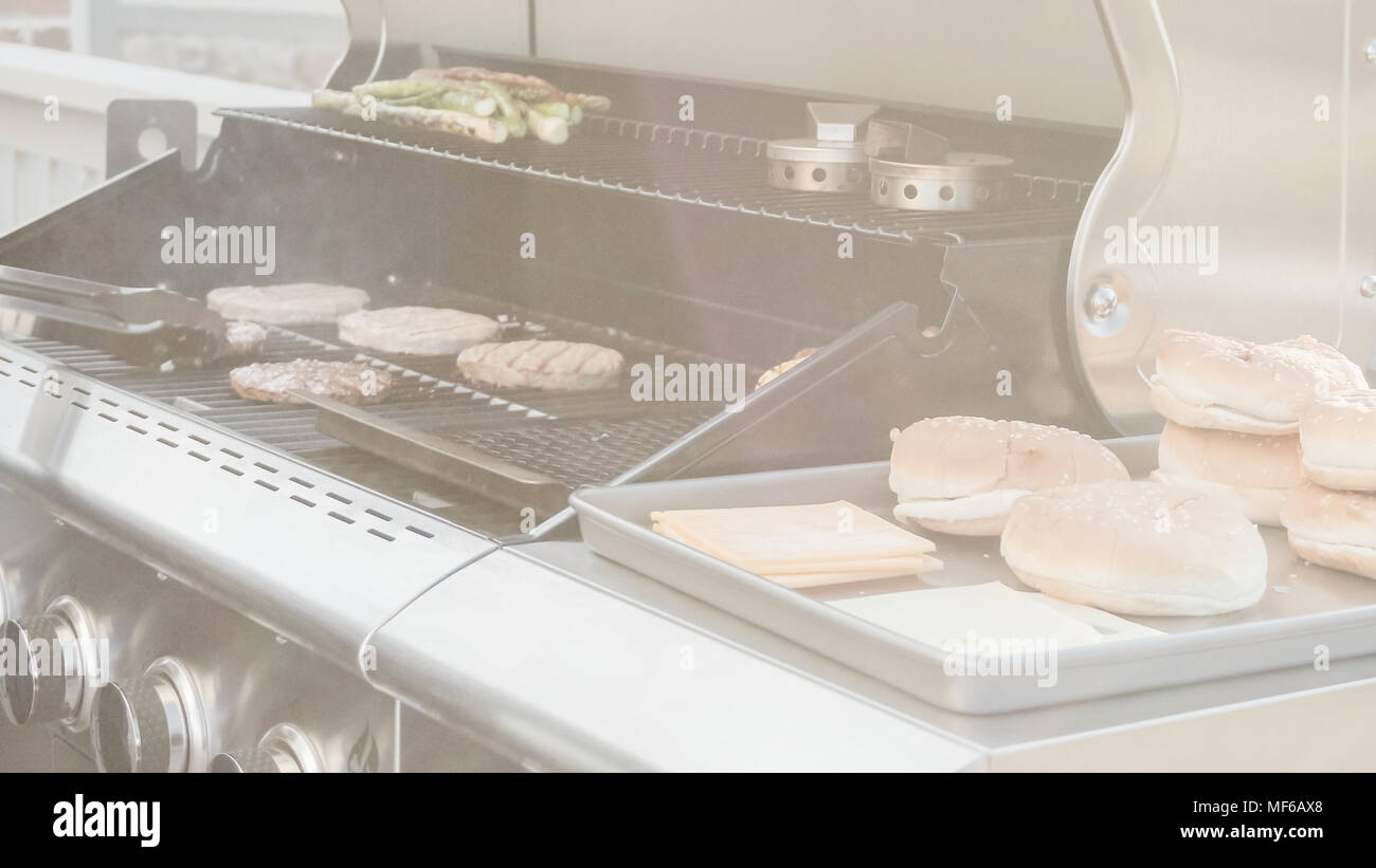 Step by step. Burger buns on the tray next to outdoor gas grill Stock ...