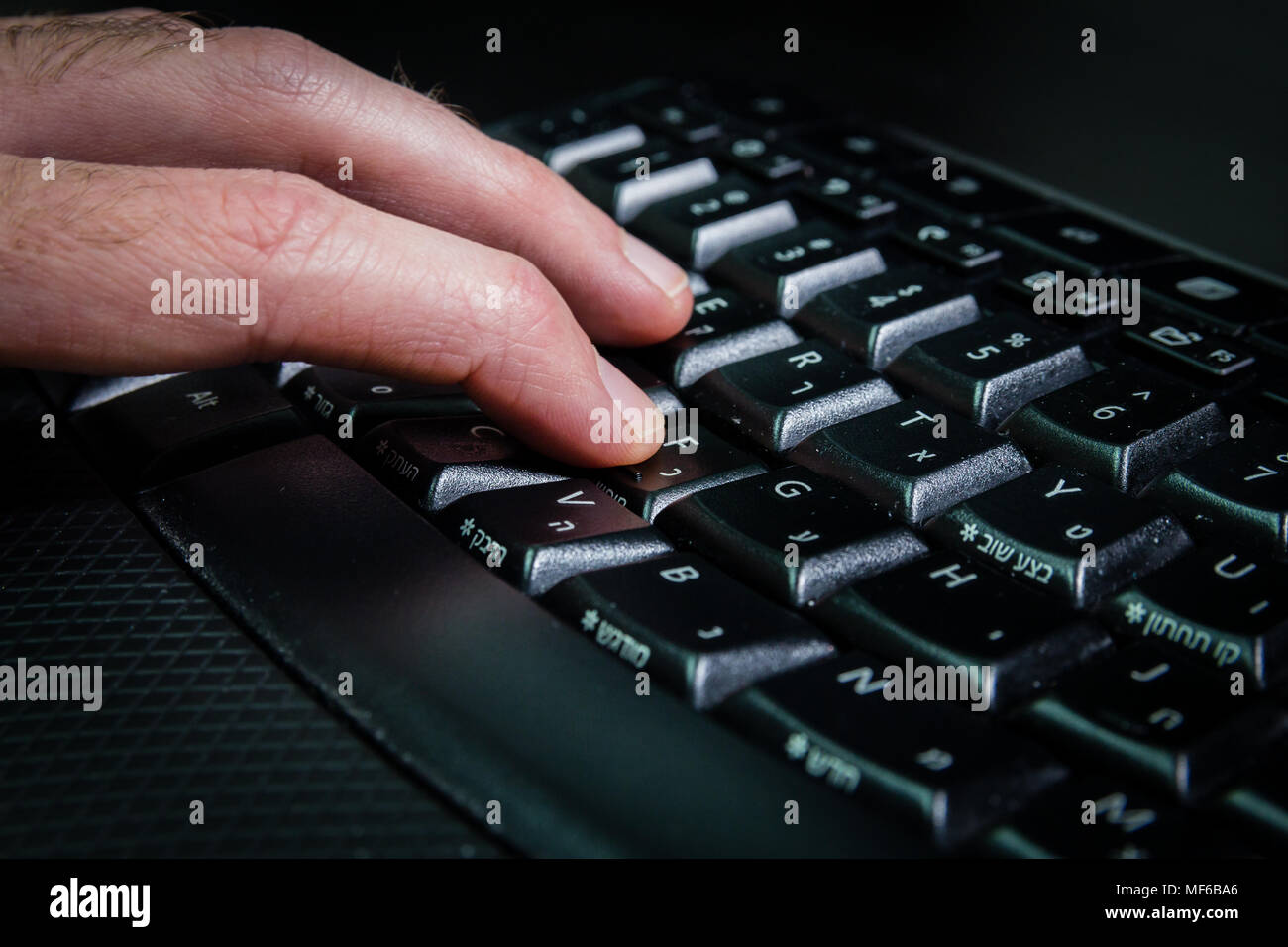 Man typing on a keyboard with letters in Hebrew and English - Wireless ...