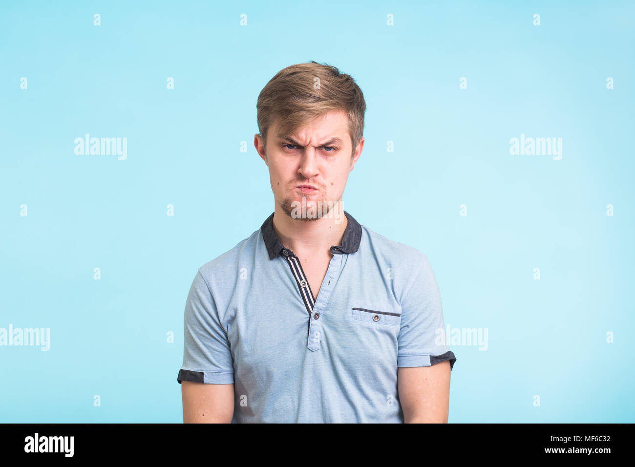 Funny angry fool man on blue background Stock Photo - Alamy
