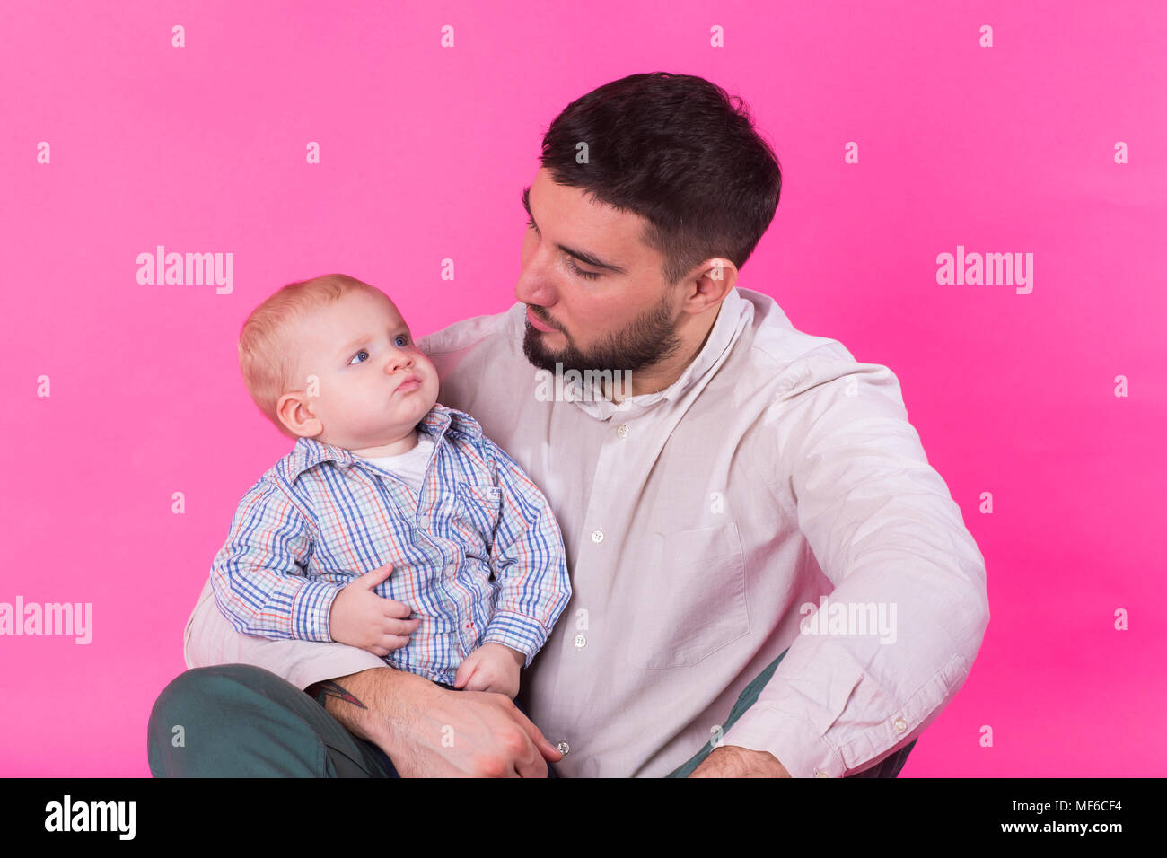 Happy father with his baby son on pink background Stock Photo - Alamy