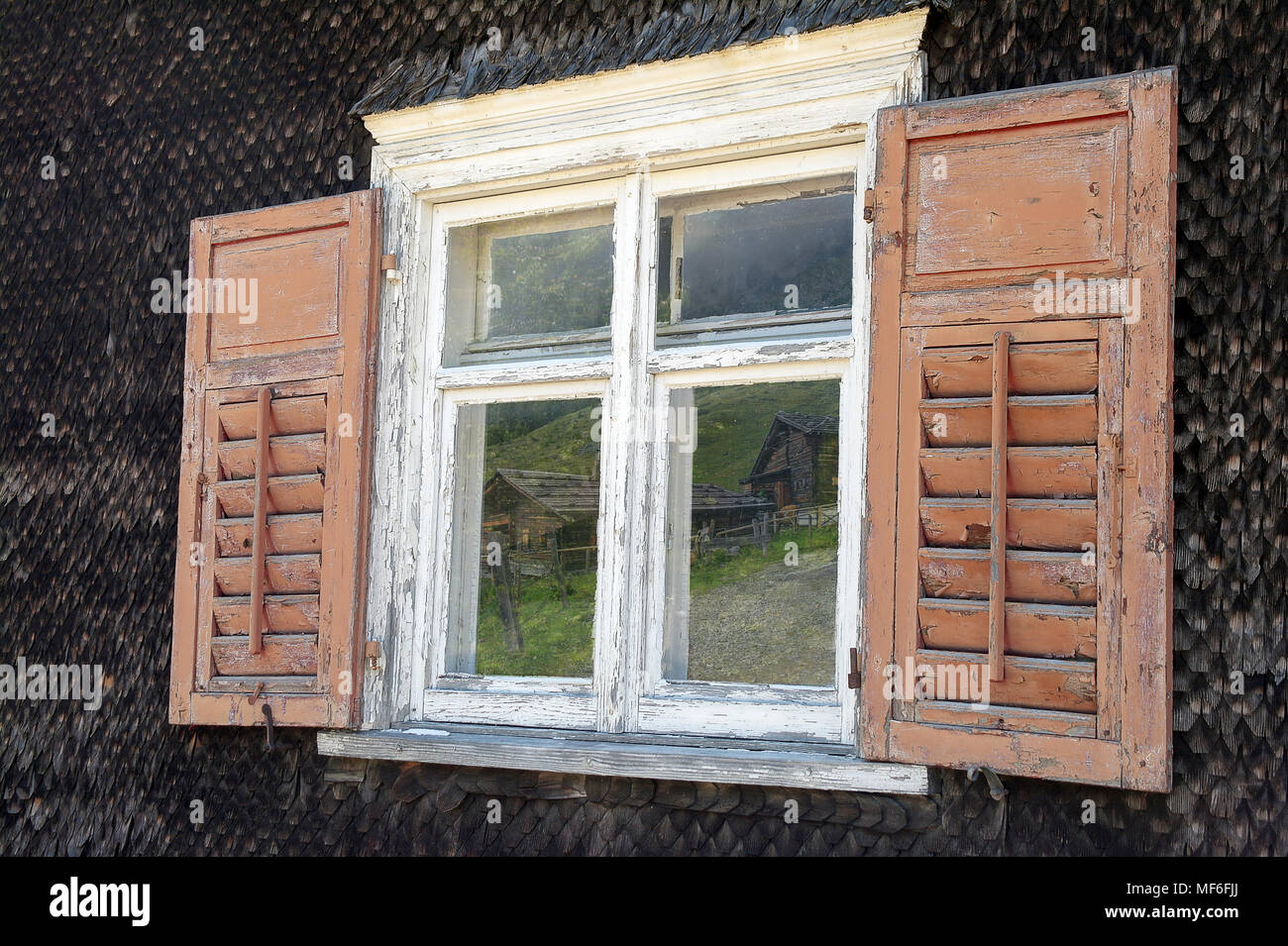 old house window with rustic wooden shutters and scenic reflection ...