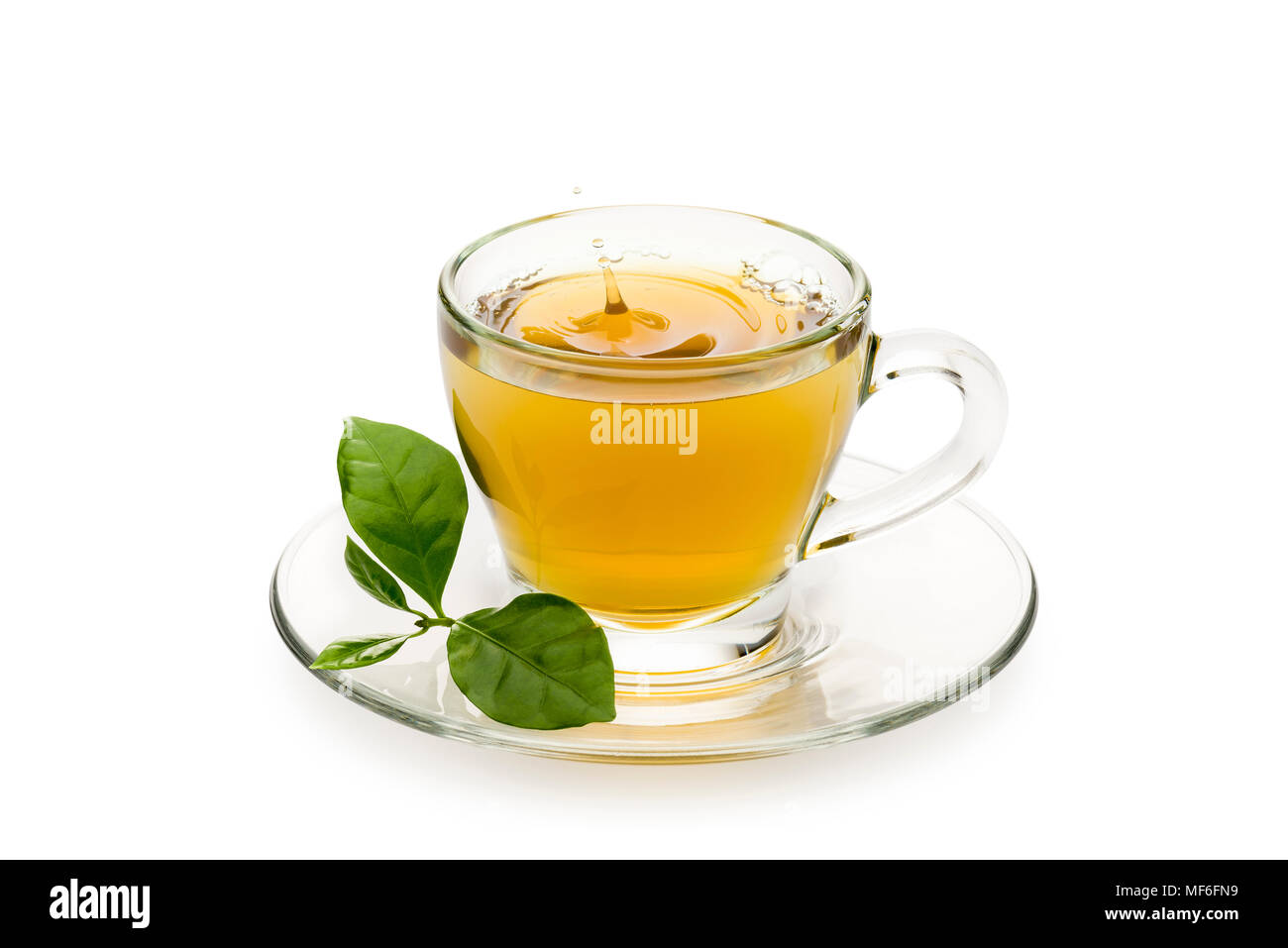 tea in glass cup with leaves and drop splashing, on white background ...