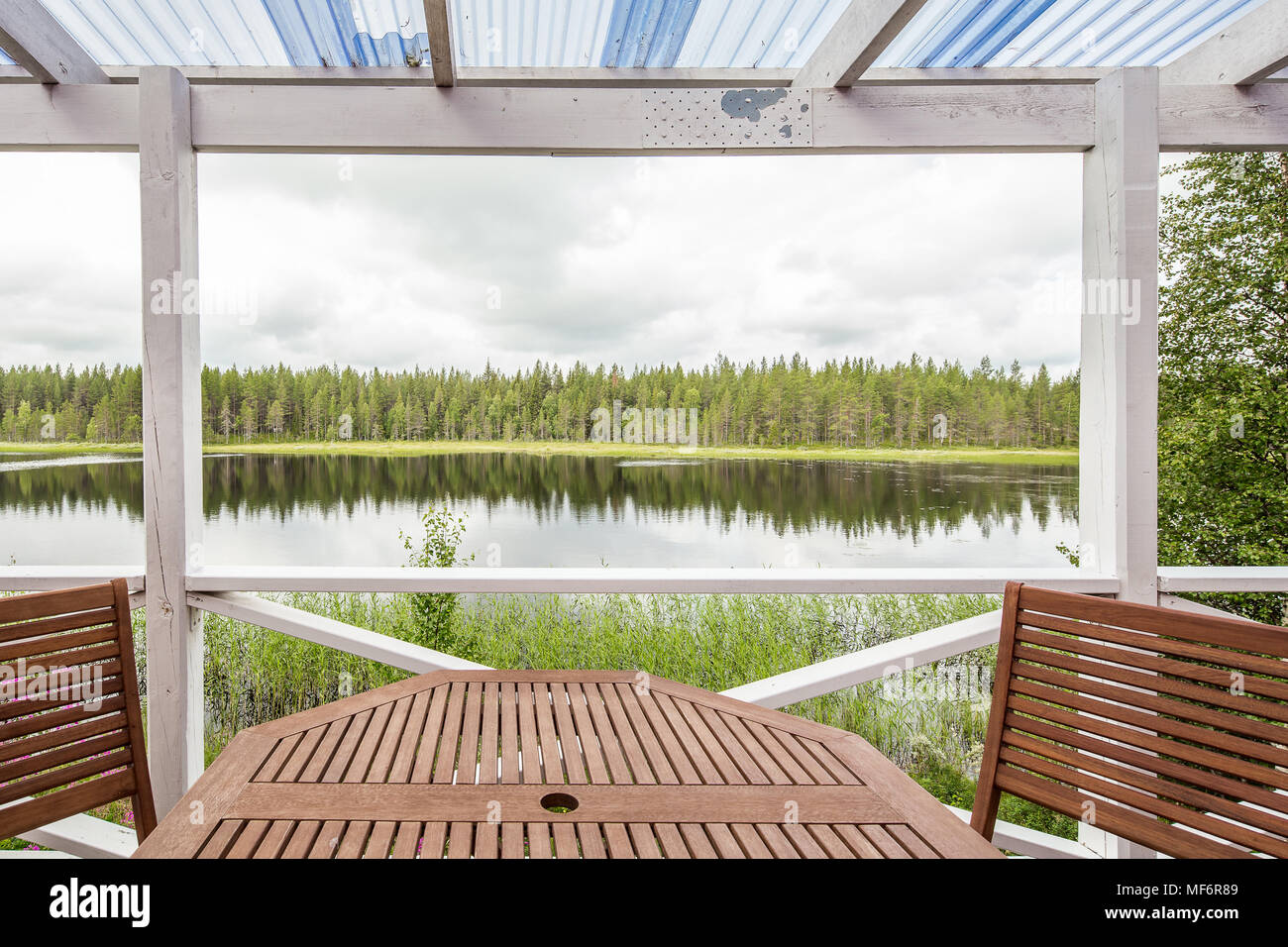 Patio with wooden furniture and a view over a lake in Sweden Stock ...