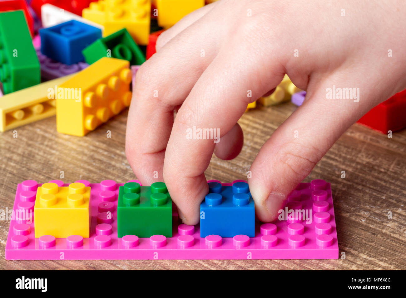 Child playing with colored toy bricks Stock Photo - Alamy