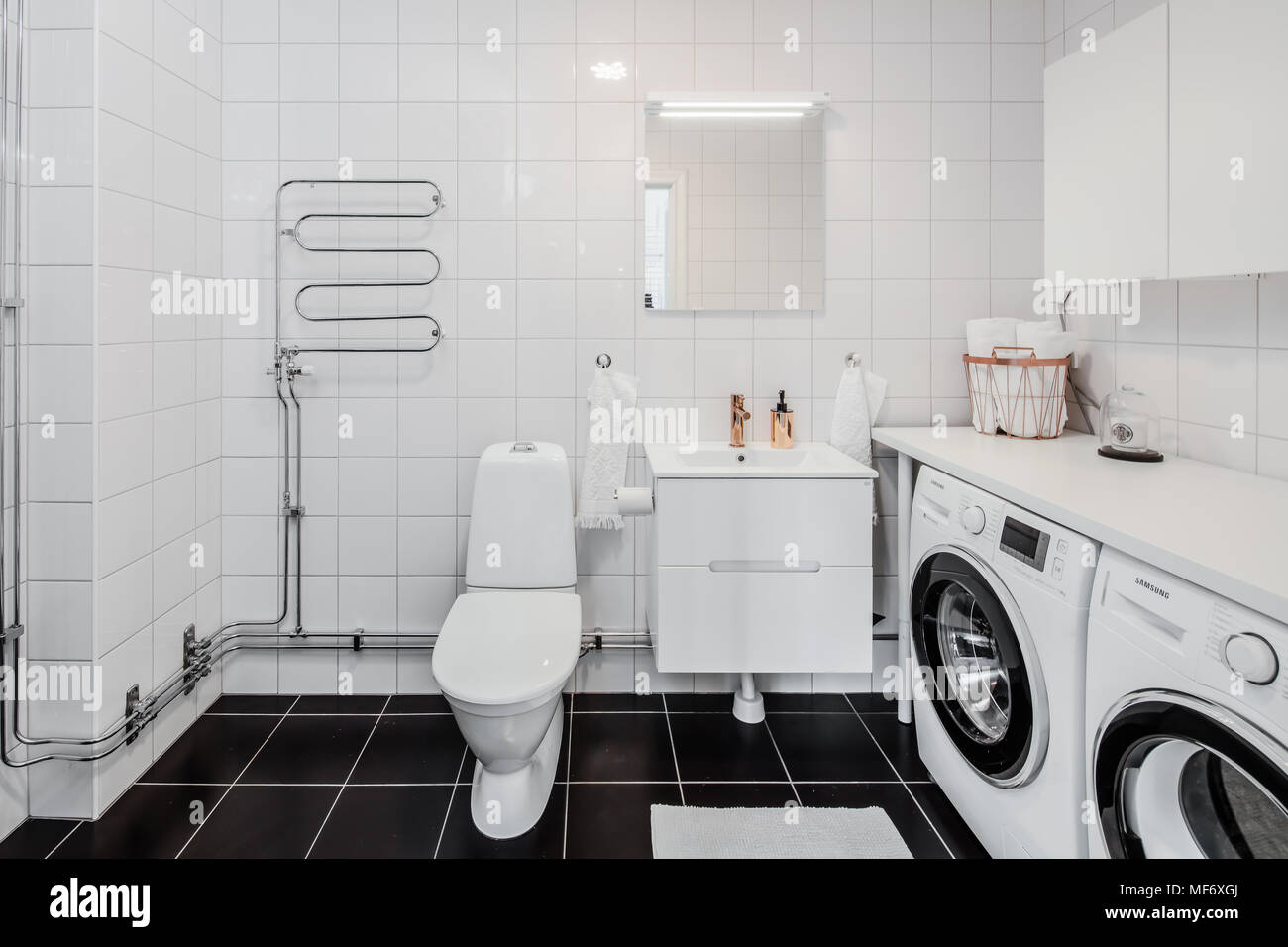 Black and white tiled bathroom with washing machines Stock Photo - Alamy