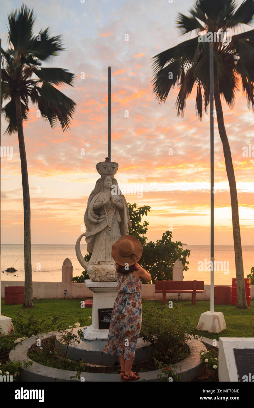 Asian female tourist praying with Virgin Mary statue at Merizo Bell ...