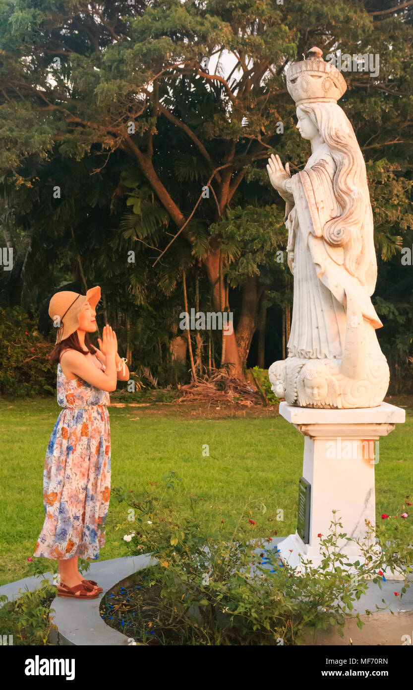 Asian female tourist praying with Virgin Mary statue at Merizo Bell ...