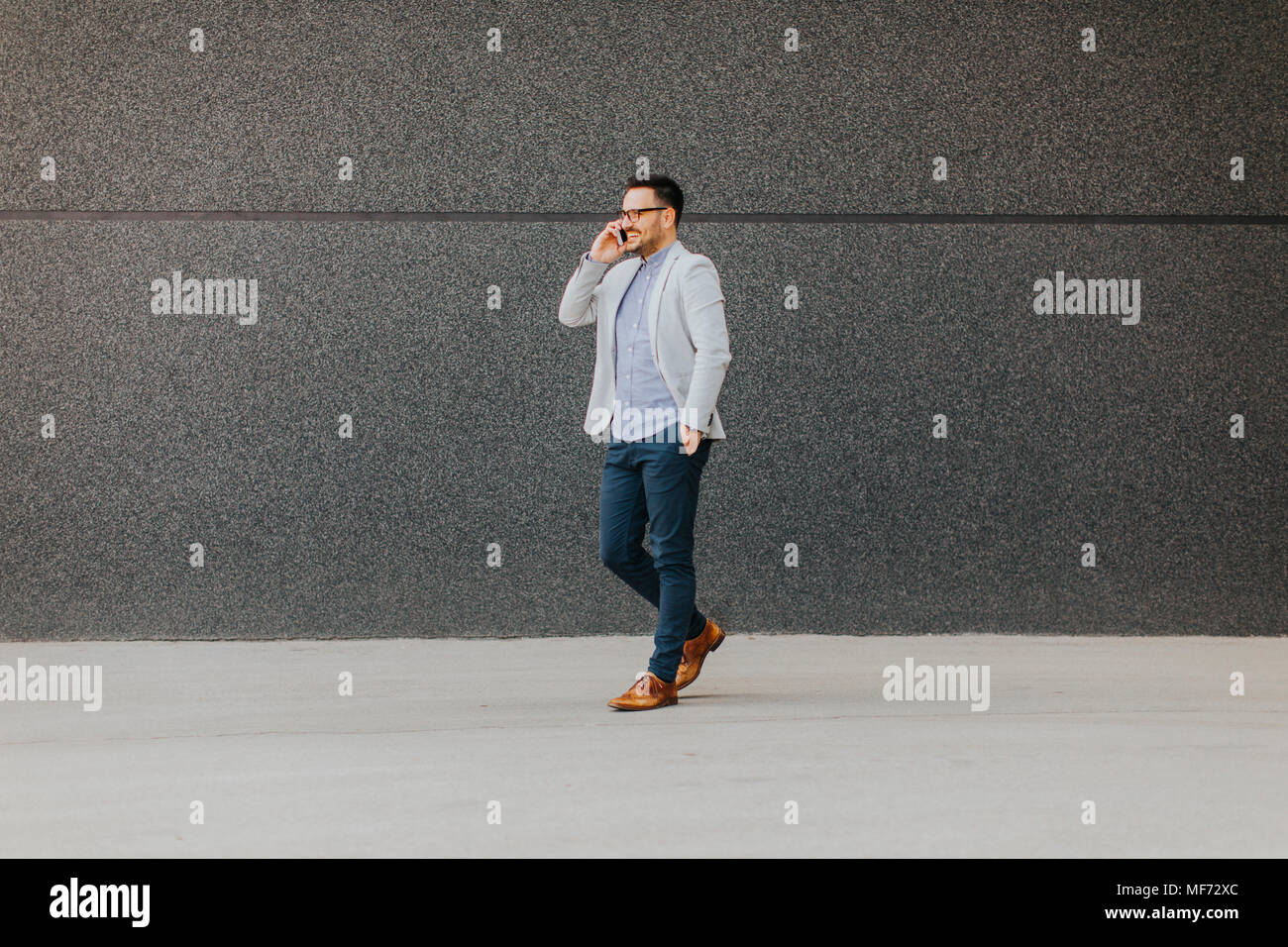 Young man walking and talking over the mobile phone outdoor Stock Photo ...