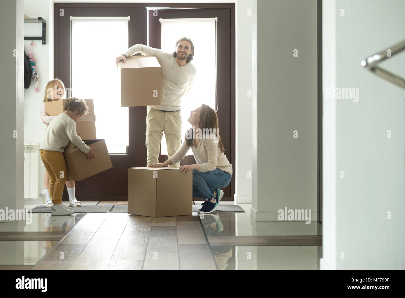 Happy family with children and boxes moving in new house Stock Photo ...