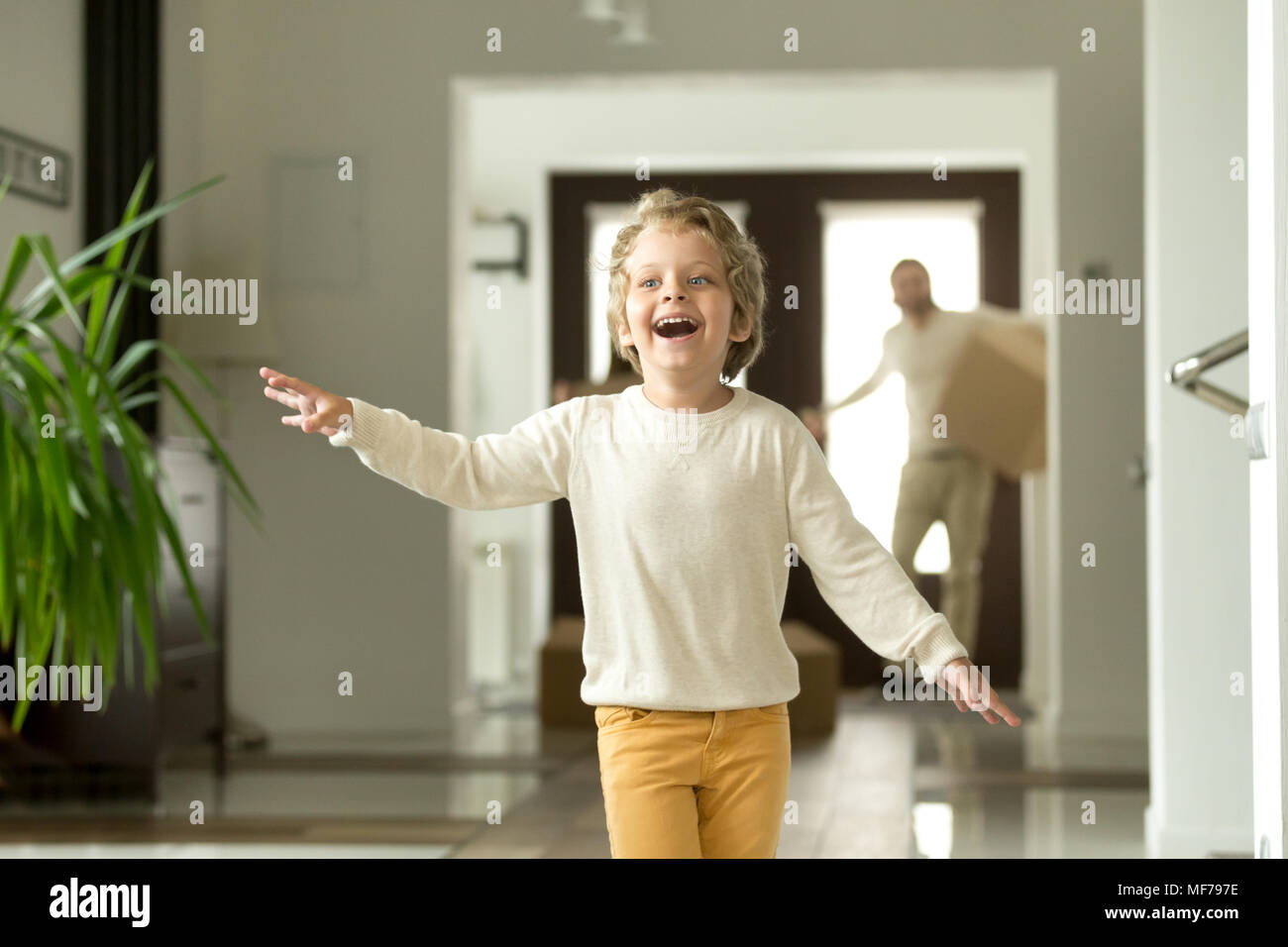 Cute kid boy running exploring new house moving with parents Stock ...