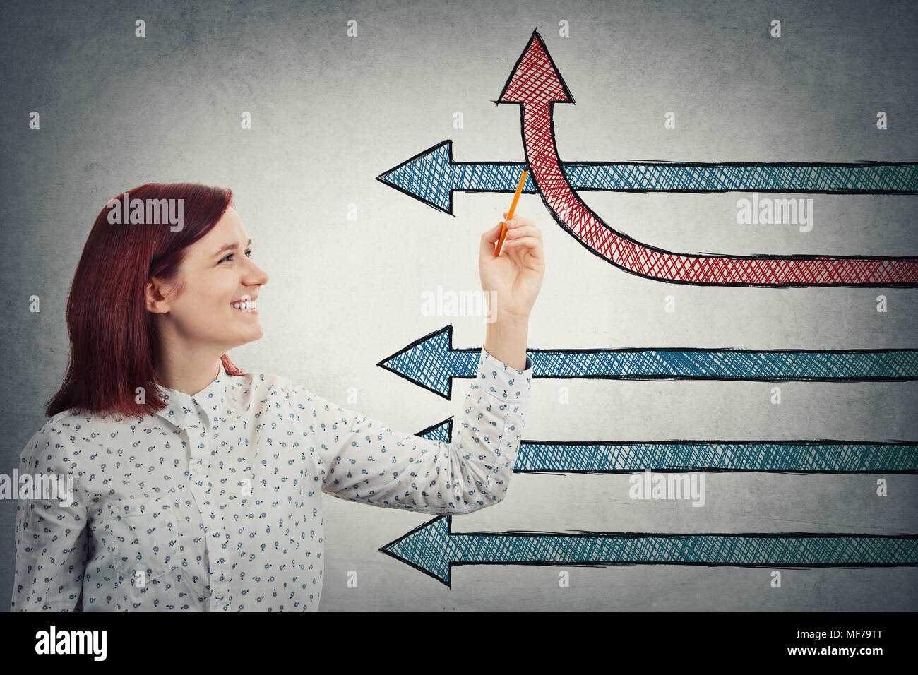 Young businesswoman drawing arrows, one of them change the direction ...