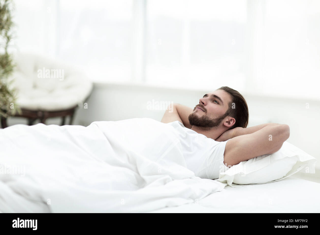 tired man resting on a comfortable bed Stock Photo - Alamy