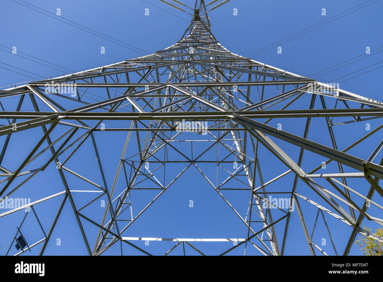 Low angle symmetrical view, from below, of an electricity pylon in the ...