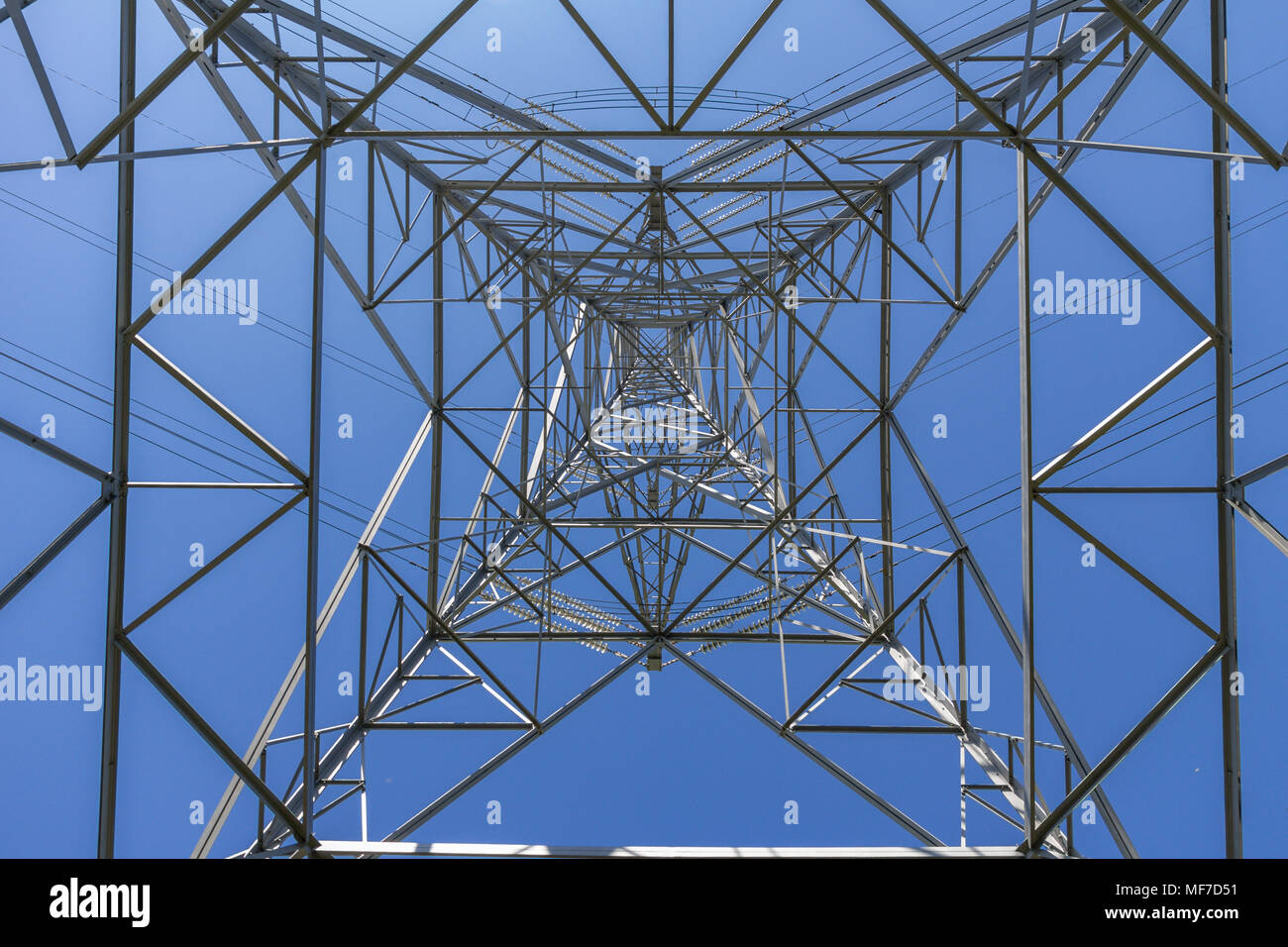 Low angle symmetrical view, from below, of an electricity pylon in the ...
