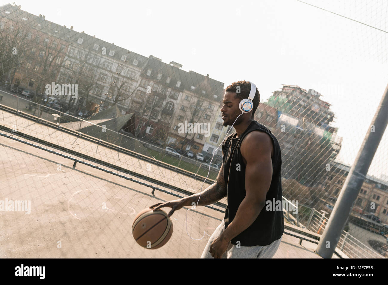 Basketball player with headphones in action on court Stock Photo - Alamy