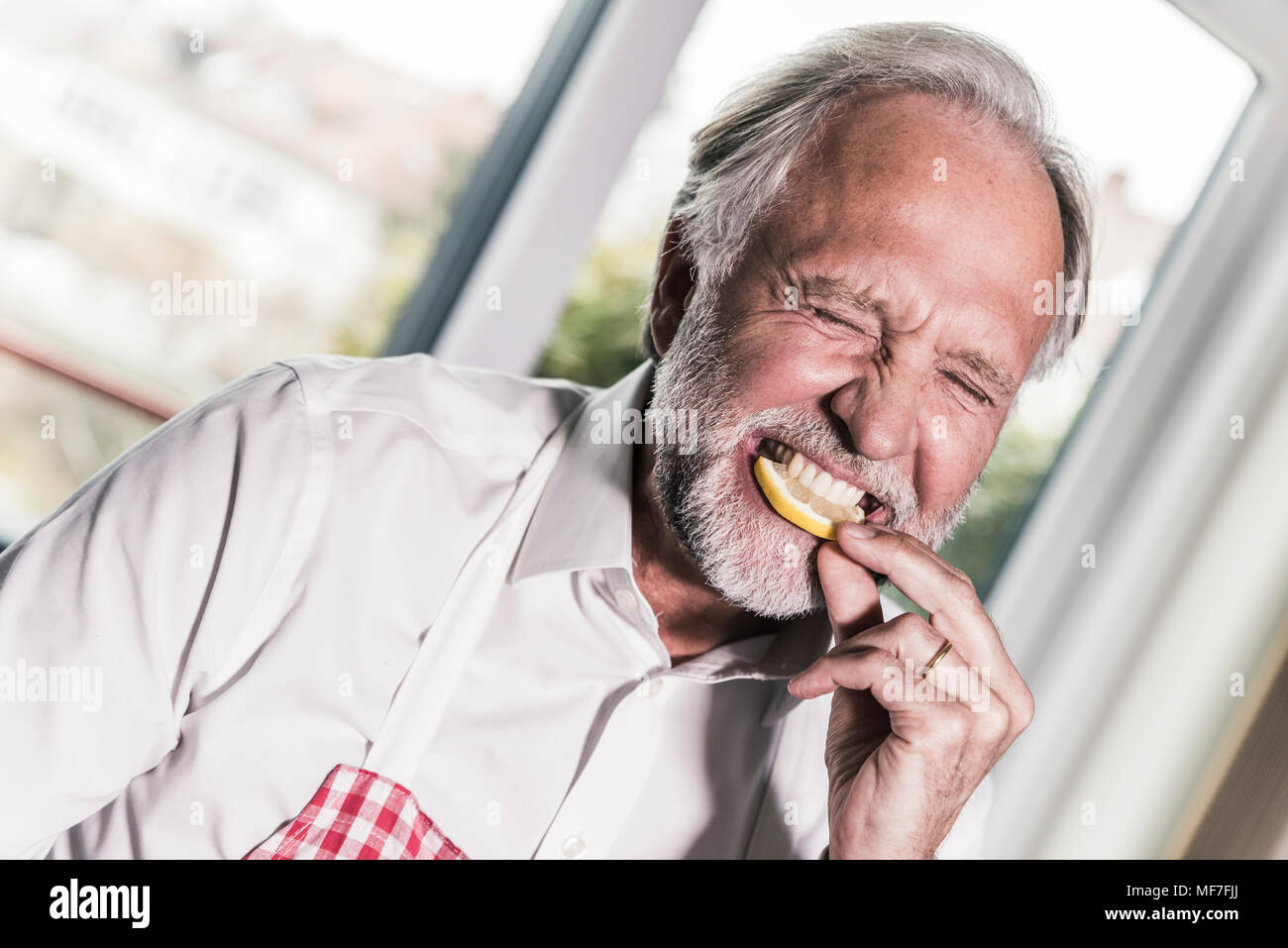Portrait of man eating lemon slice Stock Photo - Alamy