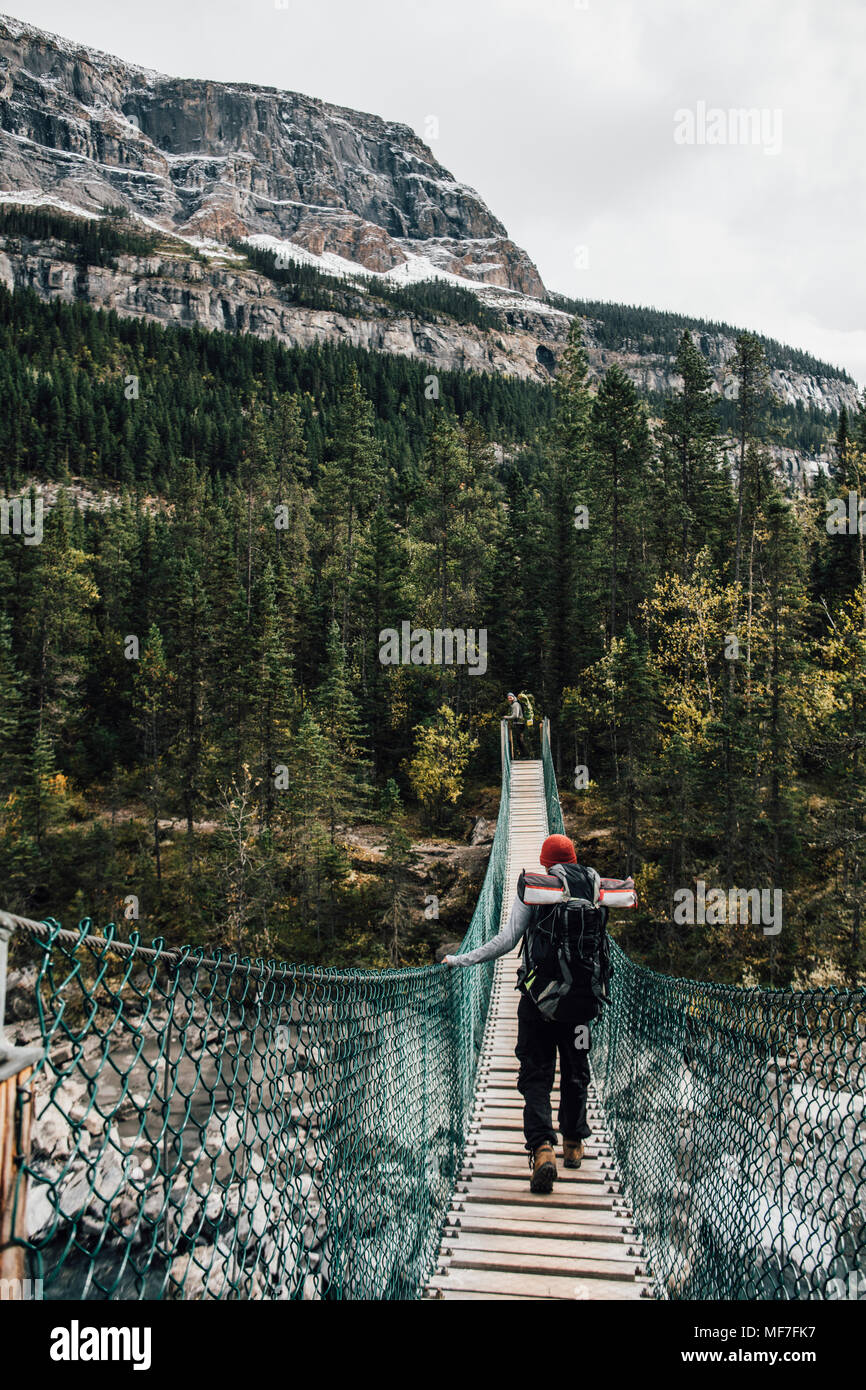 Two men on swinging bridge on berg lake trail hi-res stock photography ...