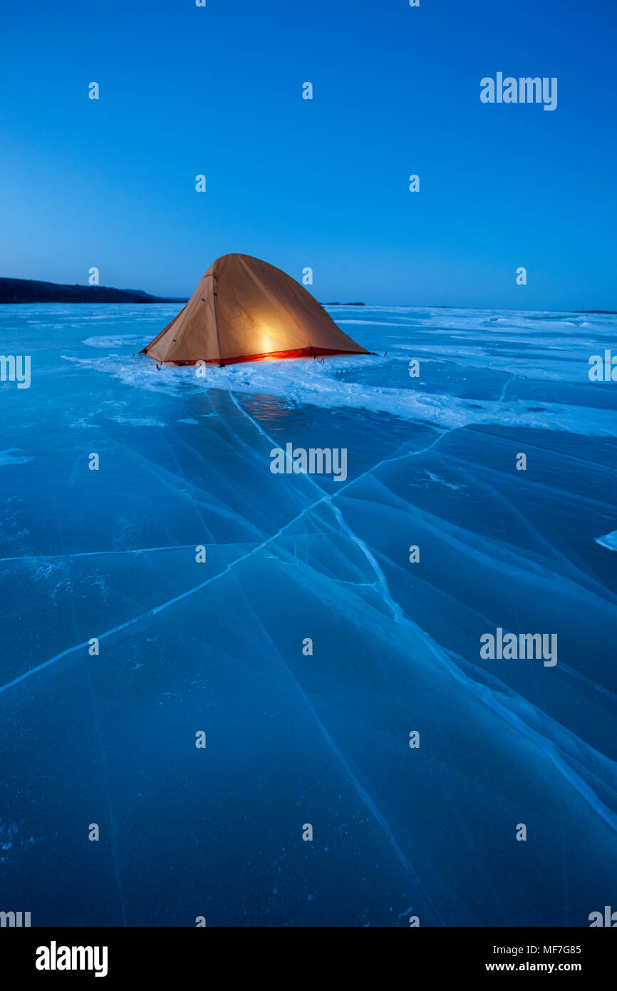 Illuminated tent on frozen zeya river at blue hour hi-res stock ...