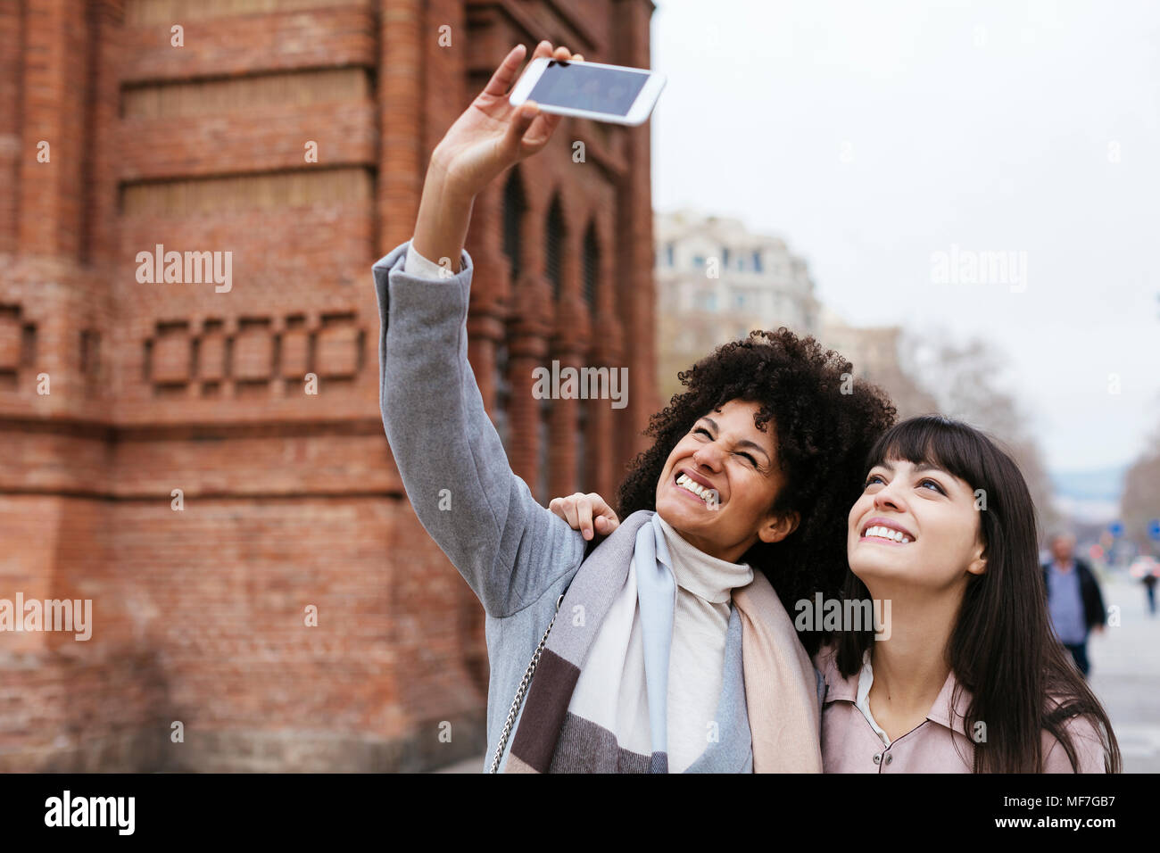 Two happy women taking a selfie at a gate hi-res stock photography and ...