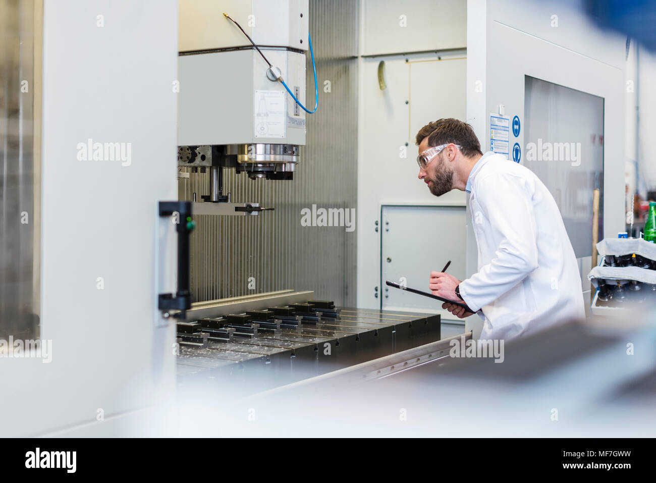 Controller with clipboard, checking machine Stock Photo - Alamy