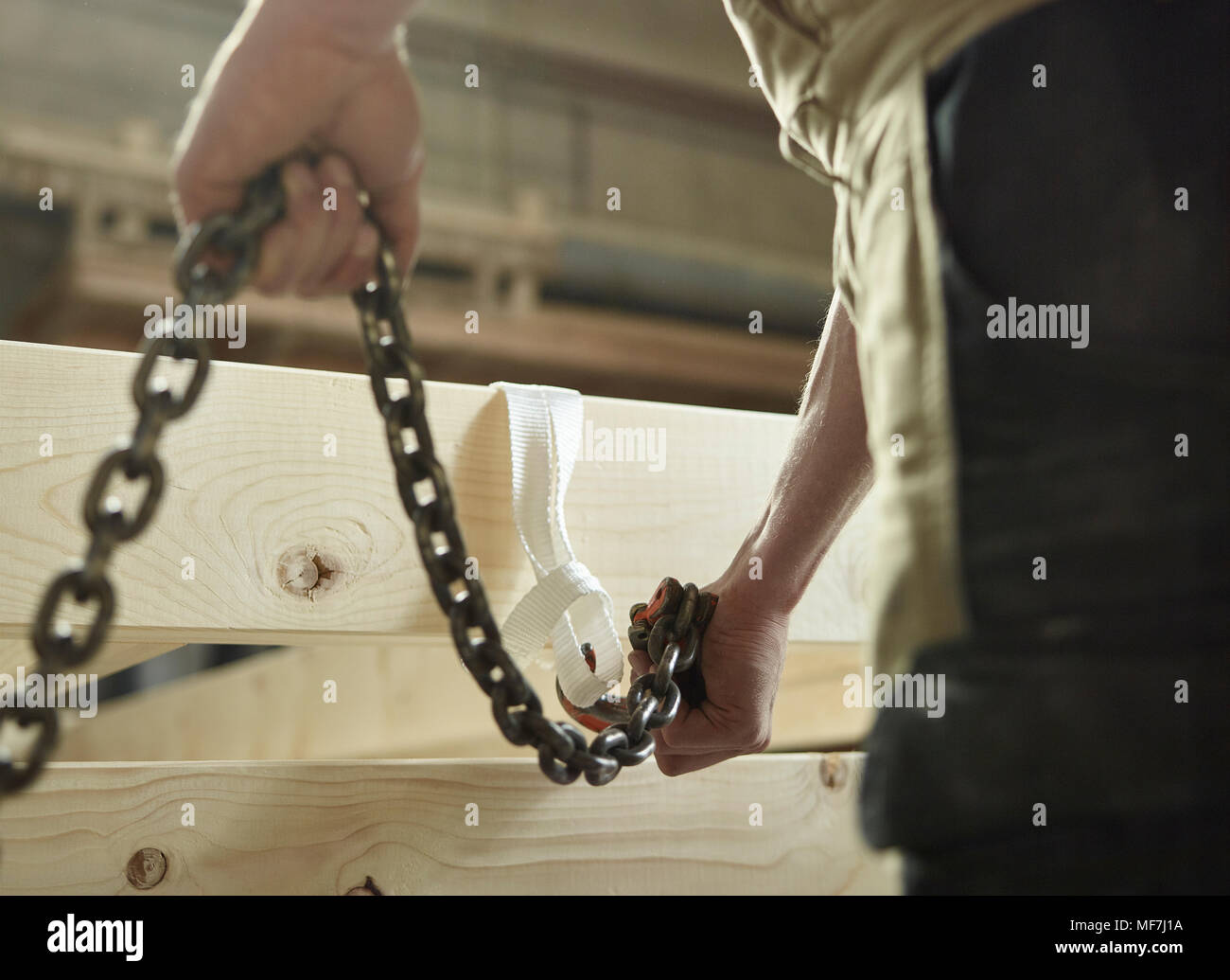 Carpenter fixing chain on wooden beam Stock Photo - Alamy