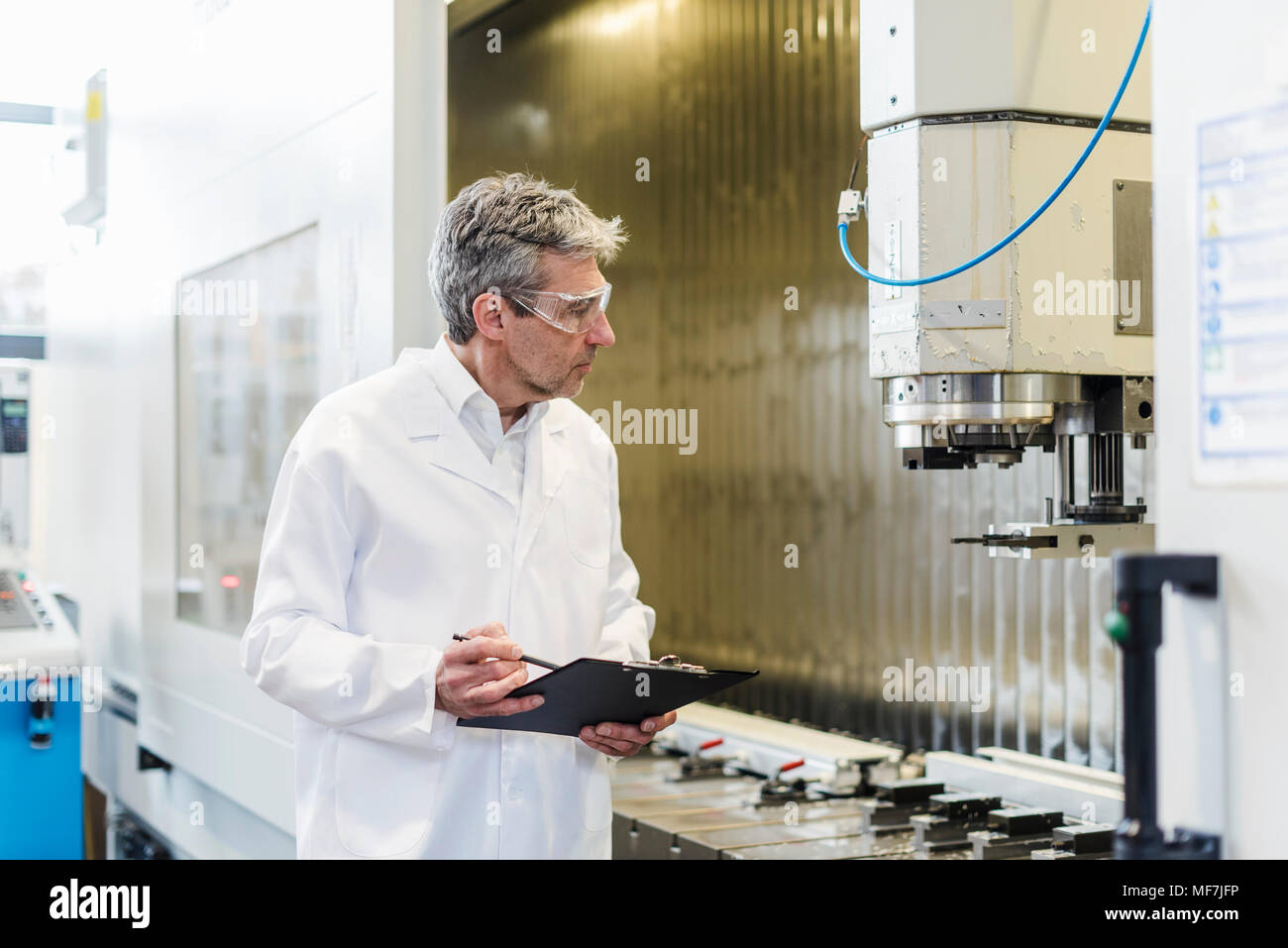 Controller with clipboard checking machine Stock Photo - Alamy