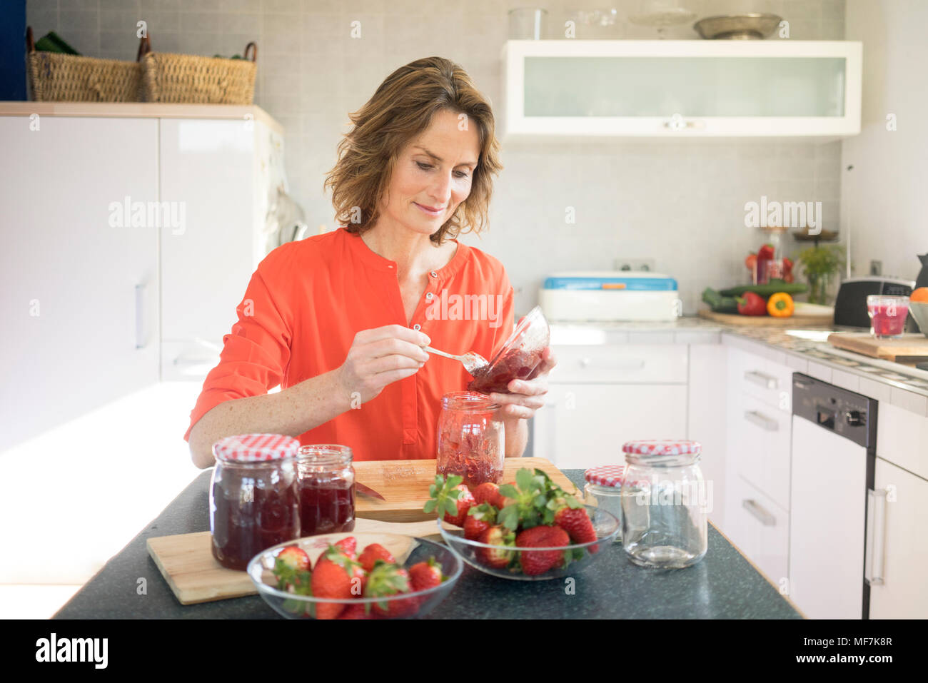 Woman making jam in kitchen hi-res stock photography and images - Alamy