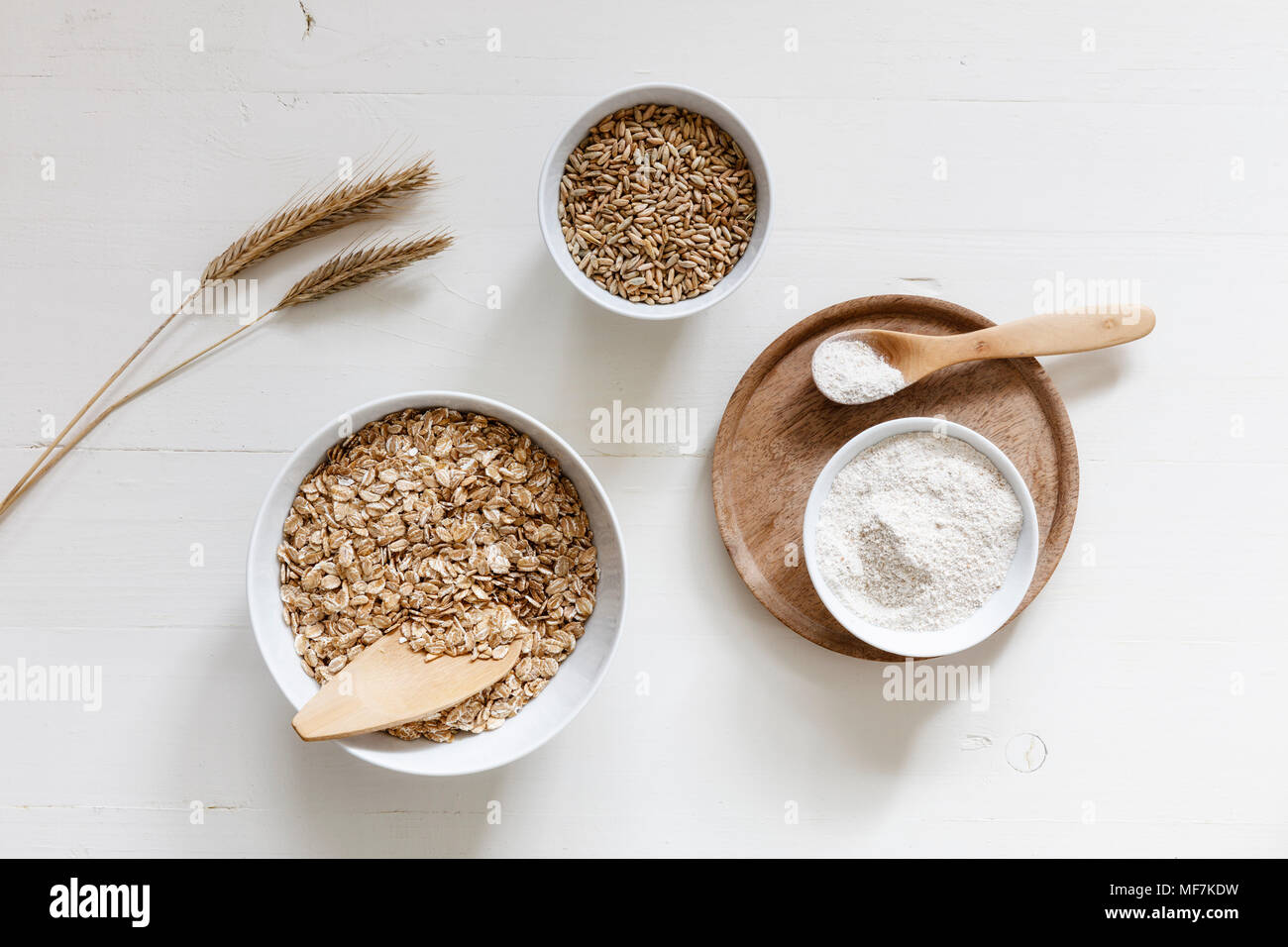 Rye ears and bowls of rye flakes, rye flour and rye grains on white ...