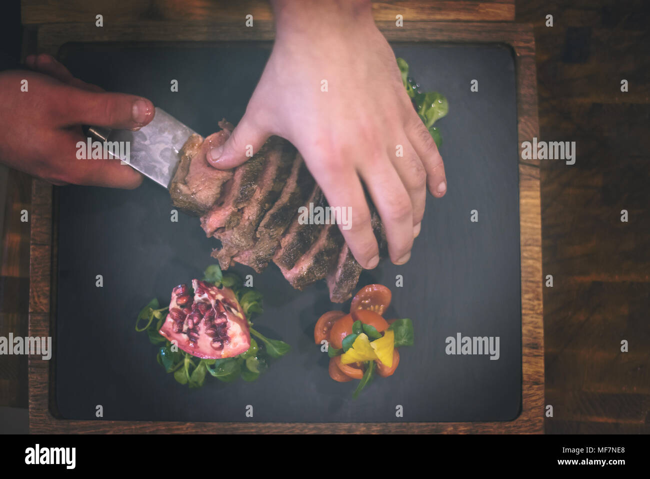 top view of Chef hands in hotel or restaurant kitchen serving beef ...