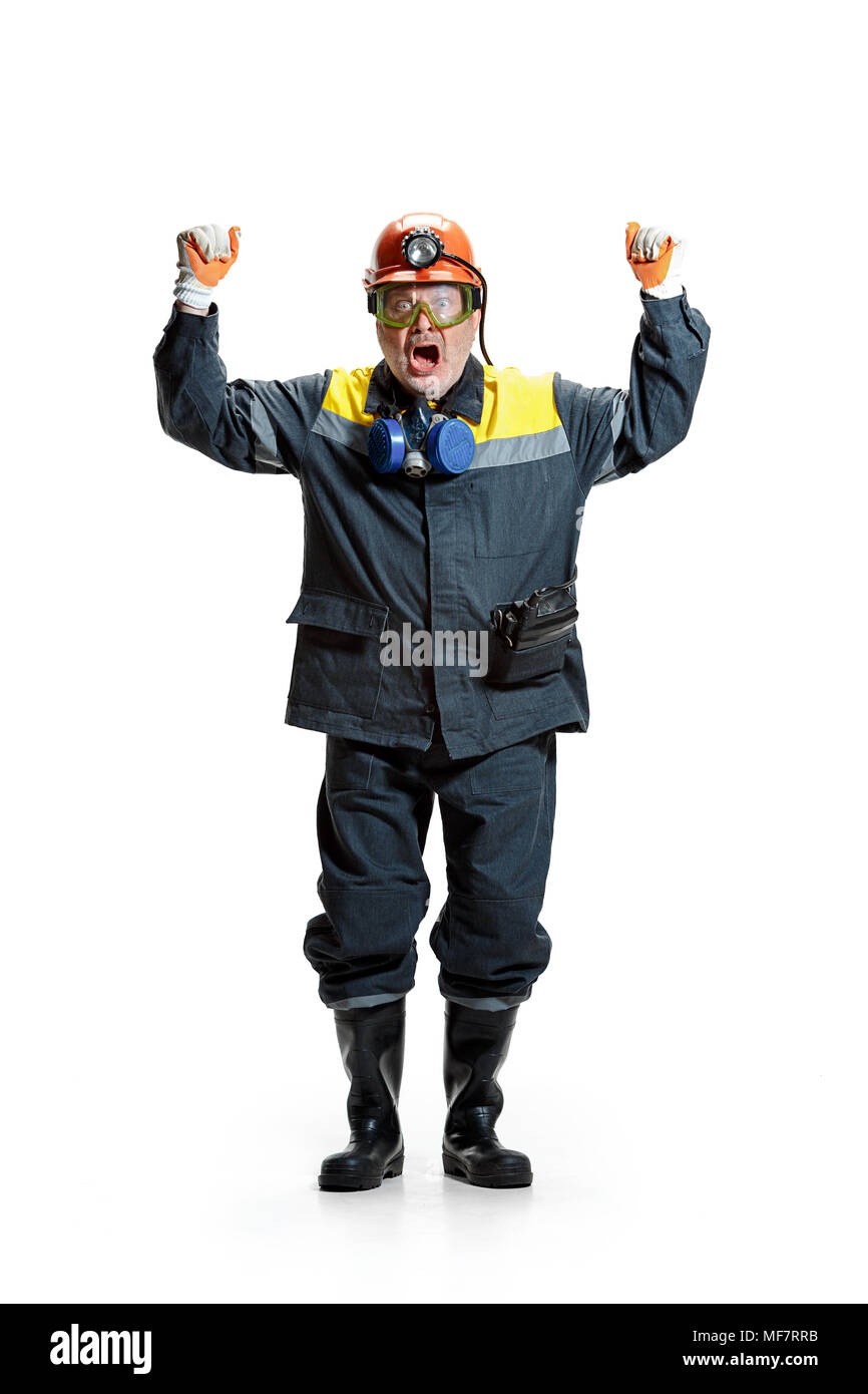 The studio shot of senior bearded male miner standing at the camera on ...