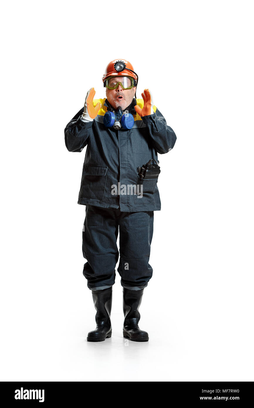 The studio shot of senior bearded male miner standing at the camera on ...