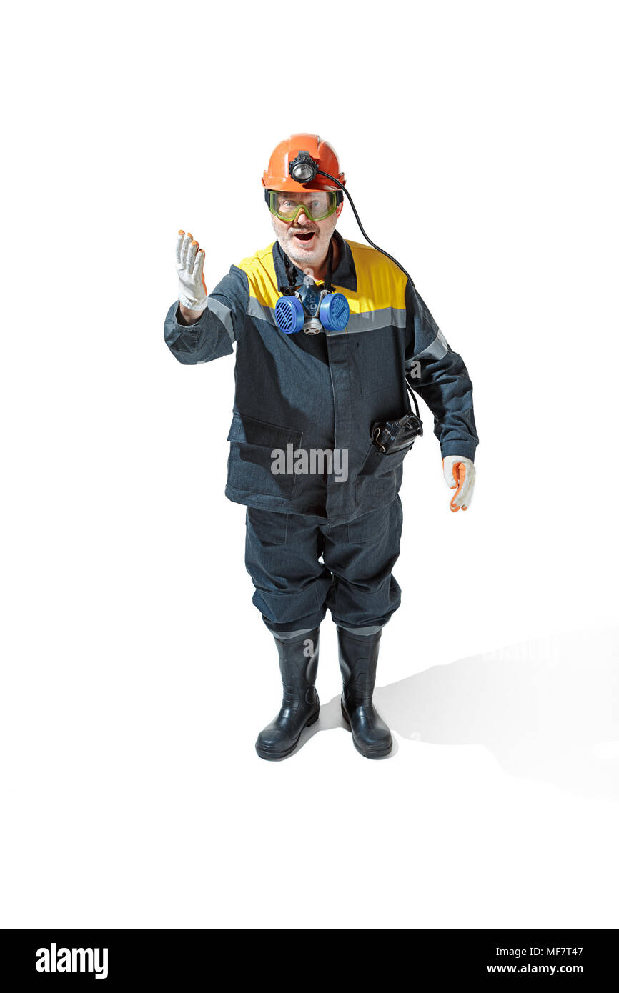 The studio shot of senior bearded male miner standing at the camera on ...