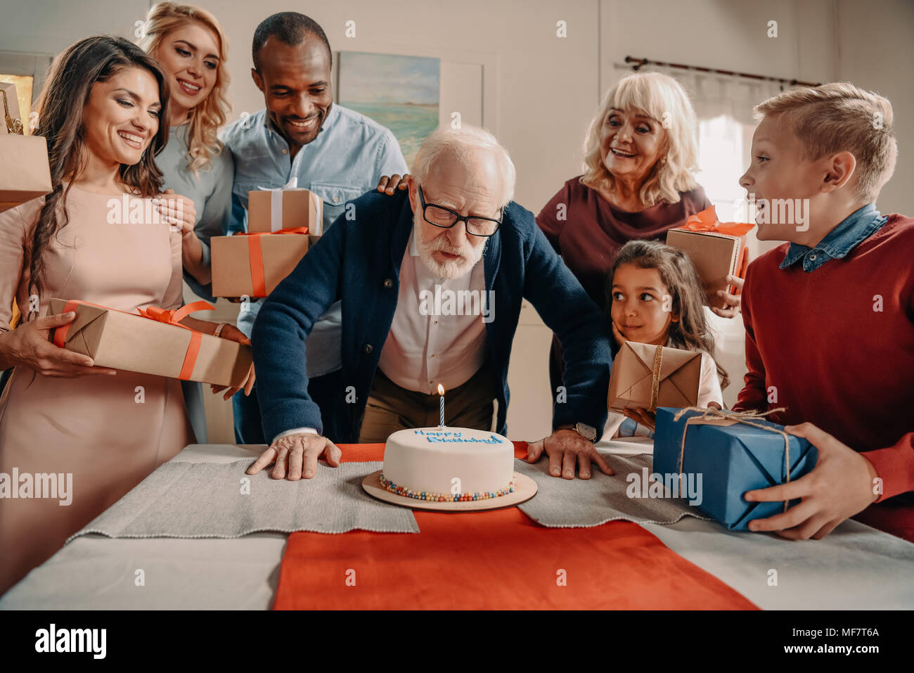 man blowing candle on birthday cake Stock Photo - Alamy