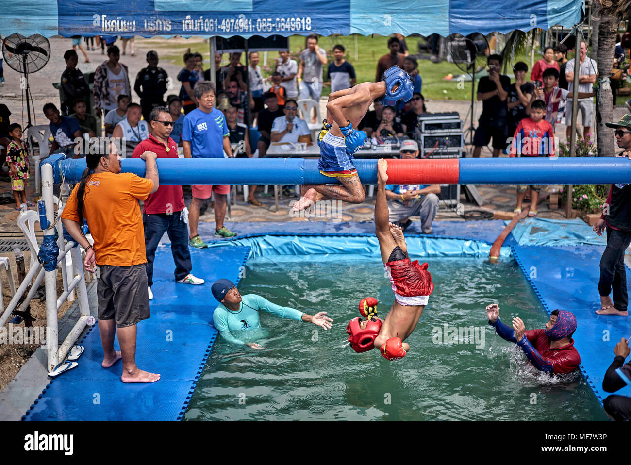 Unusual sport. Muay Thai fighters competing on a Battle Beam perched ...