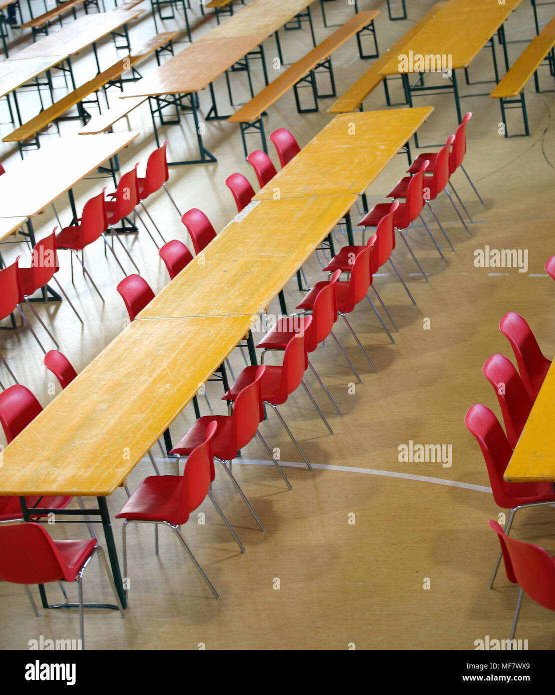 long conference table with lots of red chairs and some benches around ...