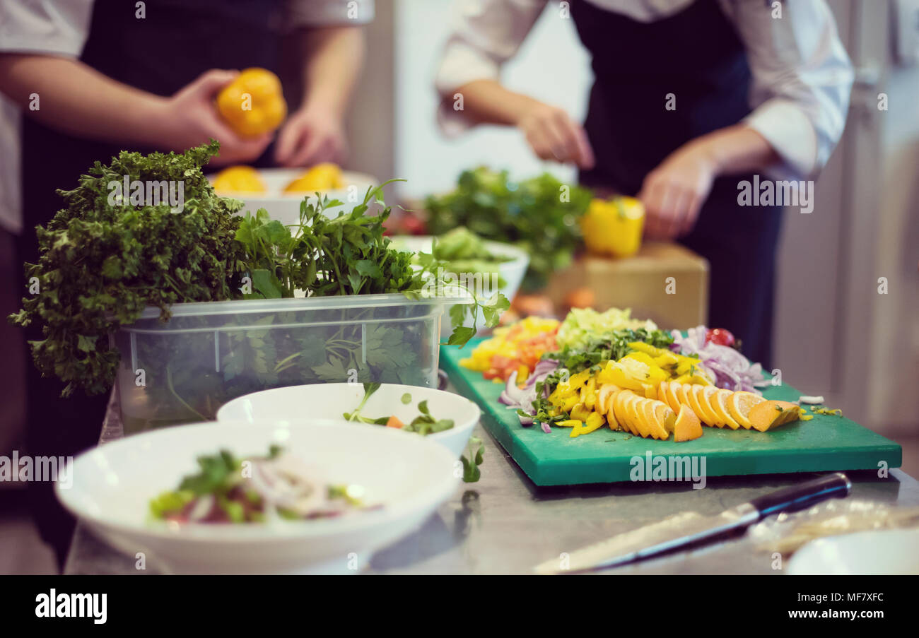 Professional team cooks and chefs preparing meals at busy hotel or ...
