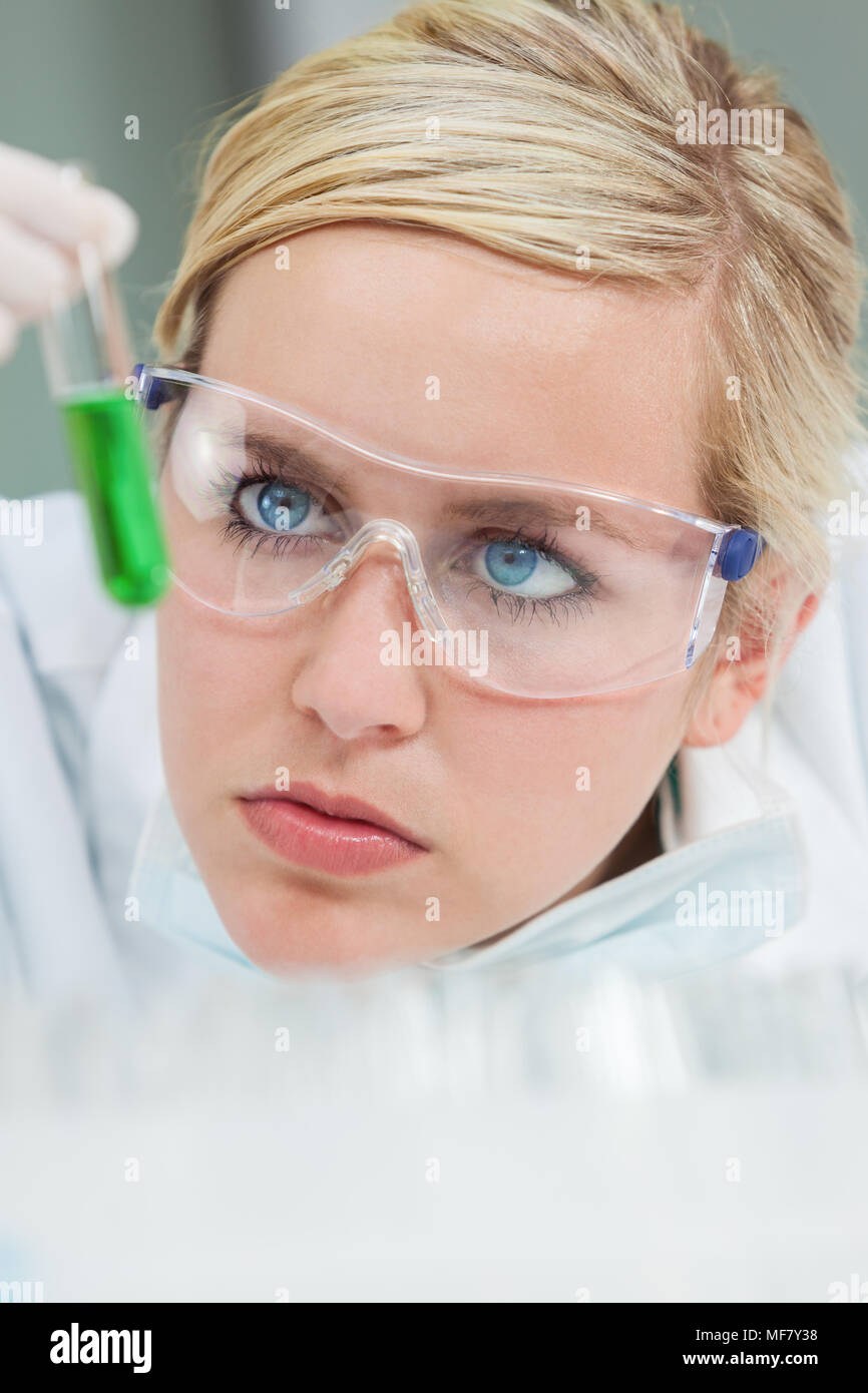 A female medical or scientific researcher or doctor looking at a green ...