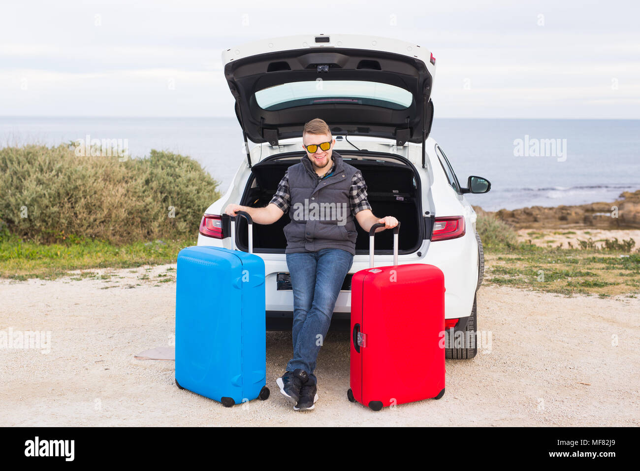 Guy standing in back of car smiling and getting ready to go. Young ...