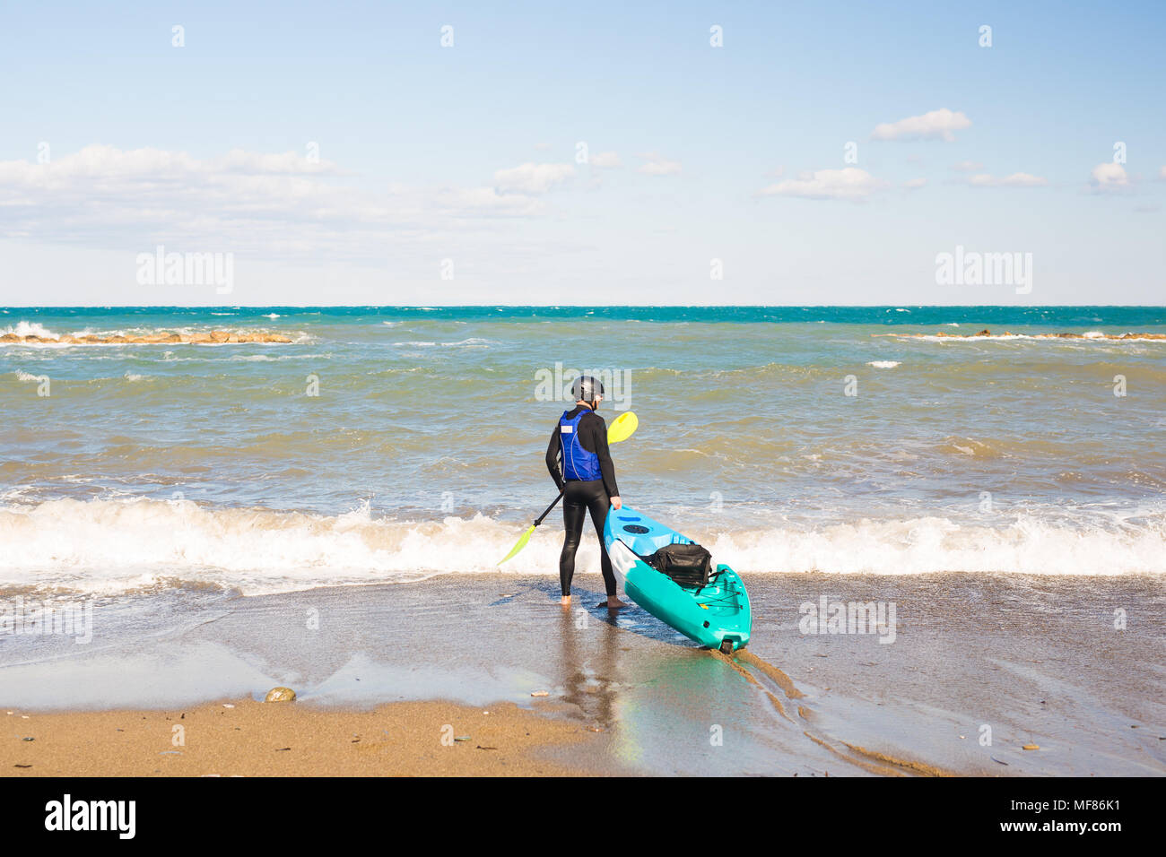 man carrying kayak at sea beach Stock Photo - Alamy