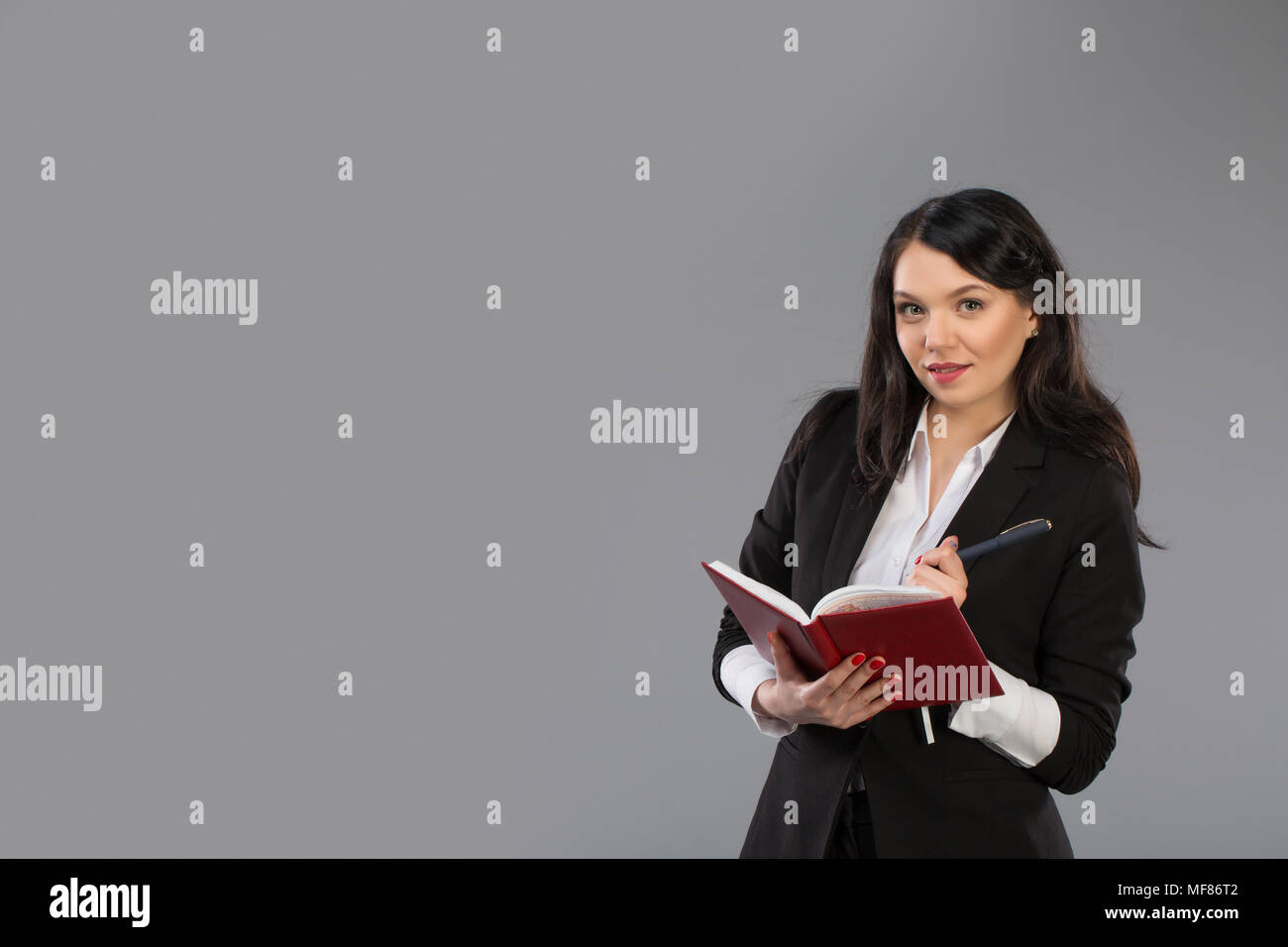 Young business woman writing down notes to notepad. Pretty thoughtful ...