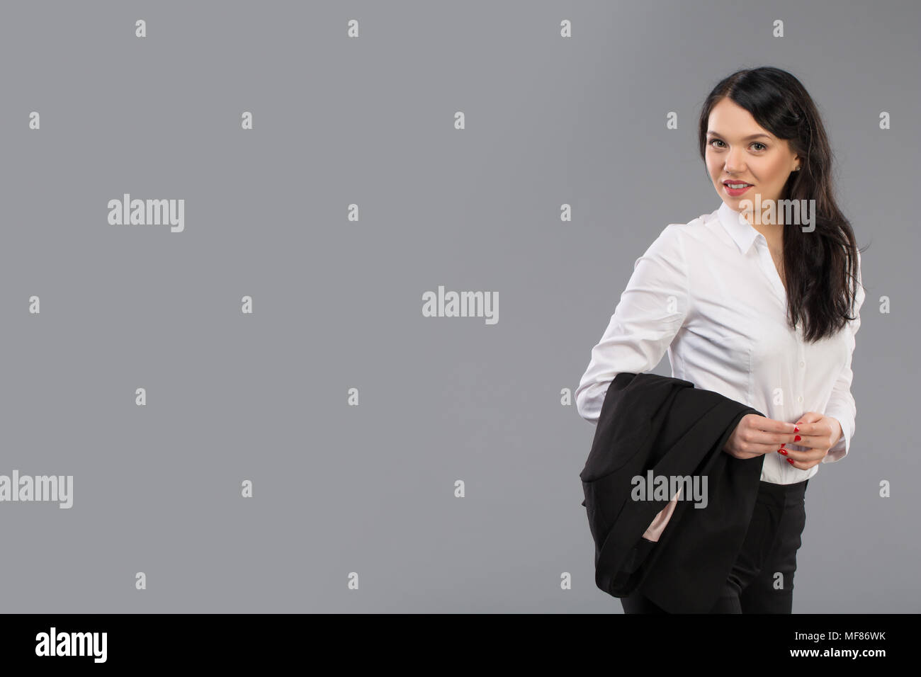 Portrait of a beautiful young business woman standing with hand holding ...