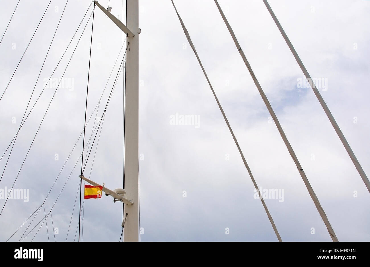 Spanish flag in mast of large sailing yacht against overcast sky in ...