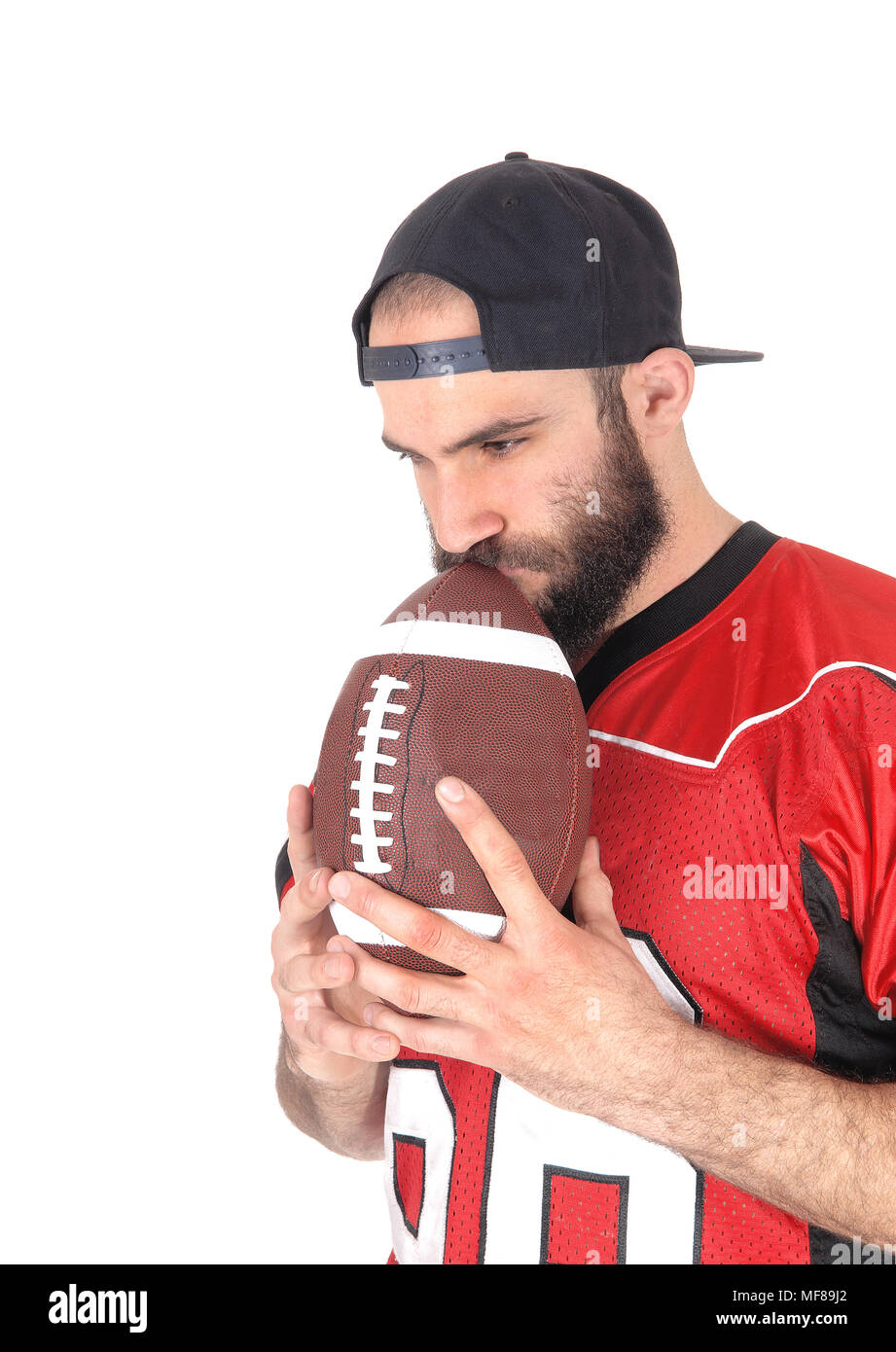 A close-up image of a football player in his jersey, holding his ...