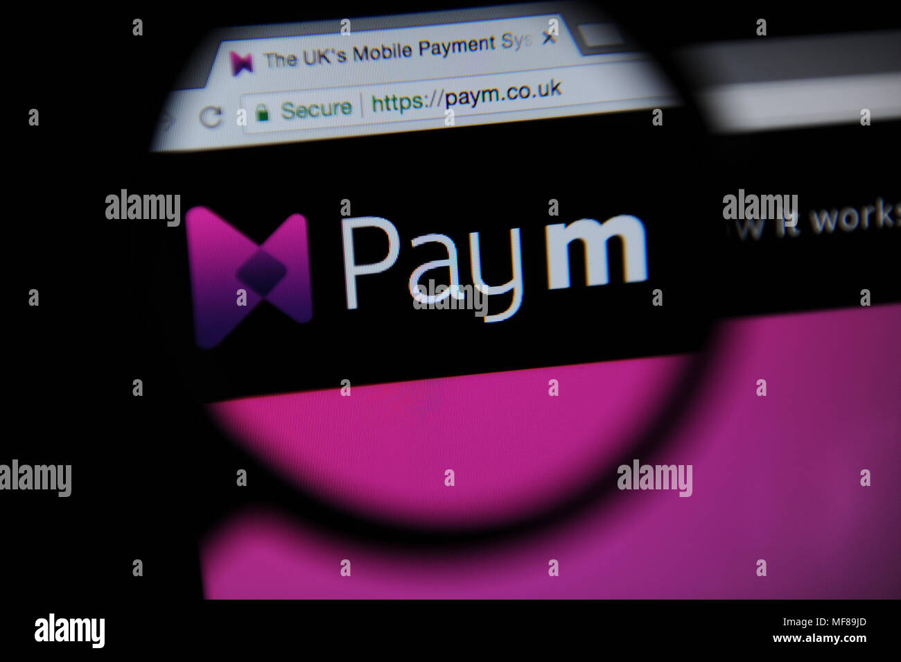 Paym the mobile payment system website seen through a magnifying glass ...