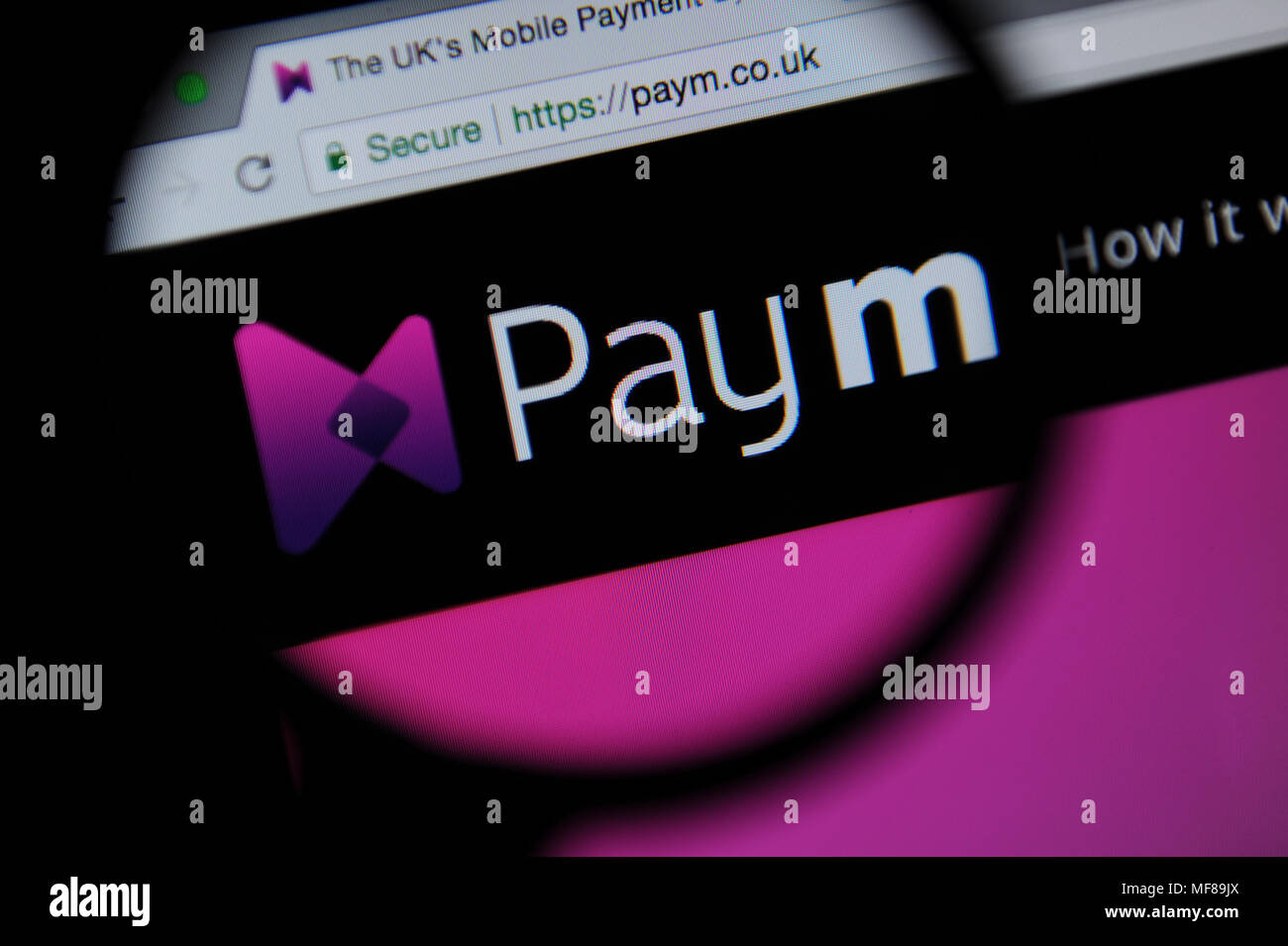 Paym the mobile payment system website seen through a magnifying glass ...