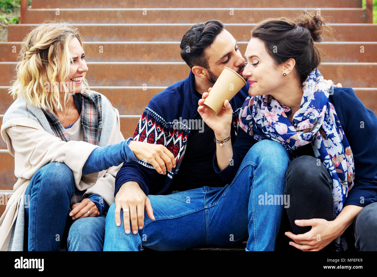 group of friends sitting outside on stairs and having fun Stock Photo ...