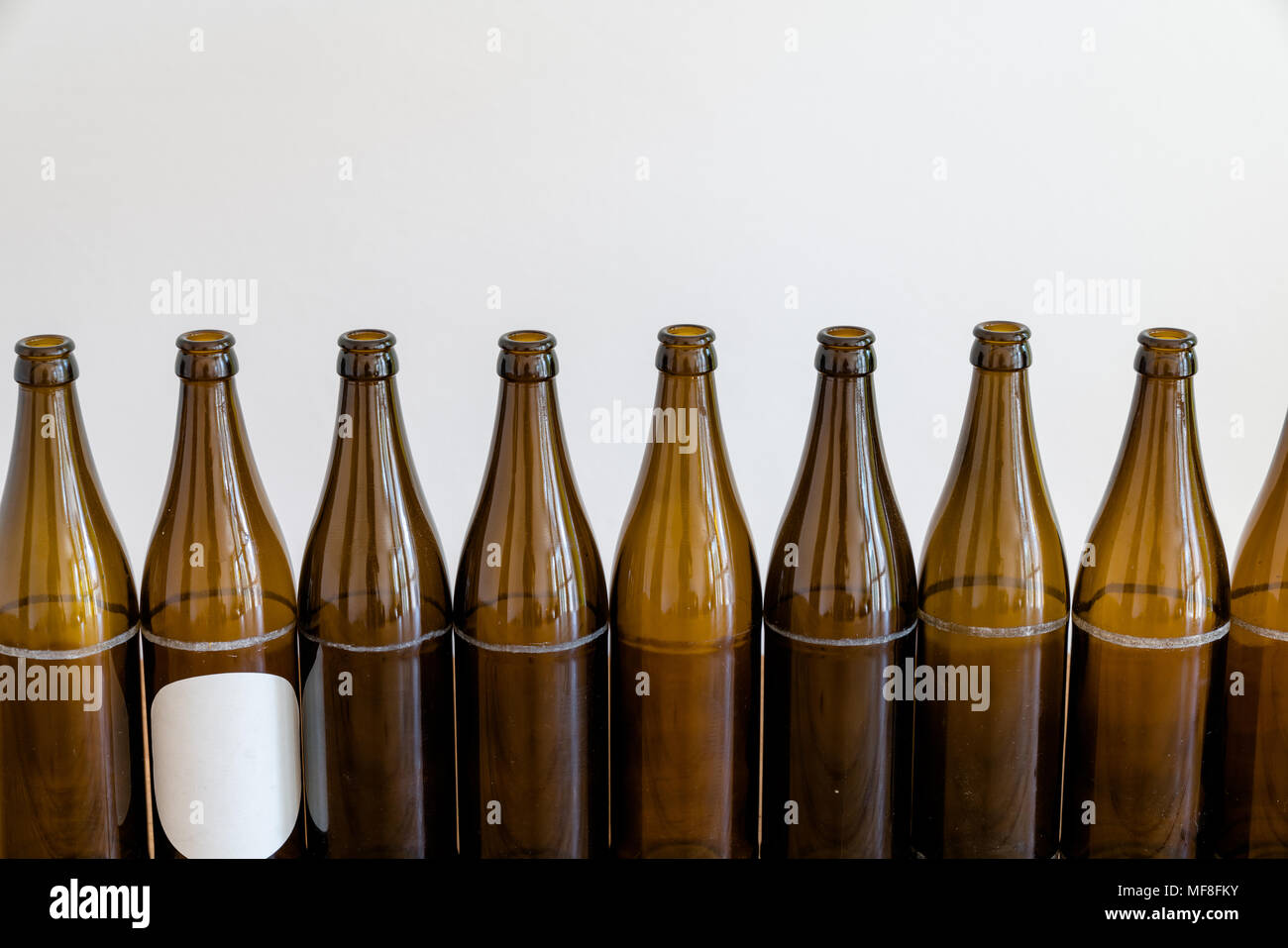 many empty brown beer bottles on a brown wooden table with plenty of ...