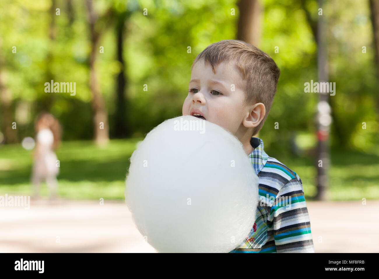 Adorable little boy eating white sweet cotton candy Stock Photo - Alamy