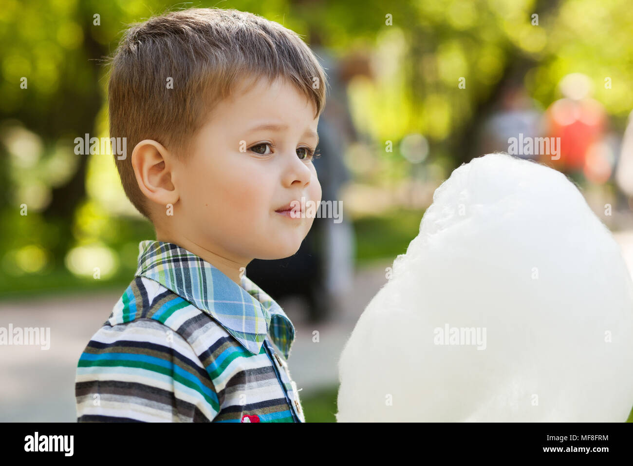 Adorable little boy eating white sweet cotton candy Stock Photo - Alamy