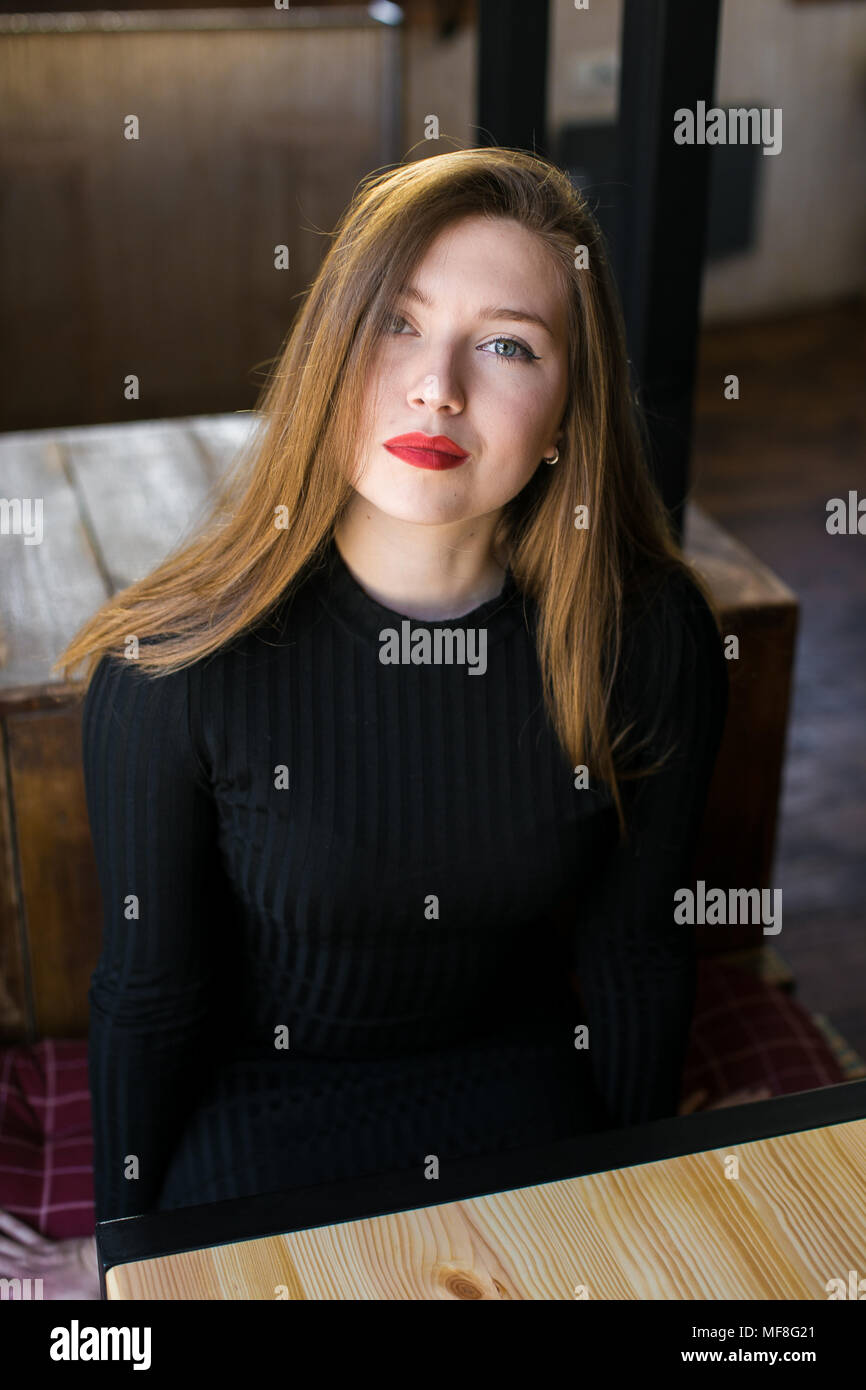 Girl sitting near table in cafe Stock Photo - Alamy